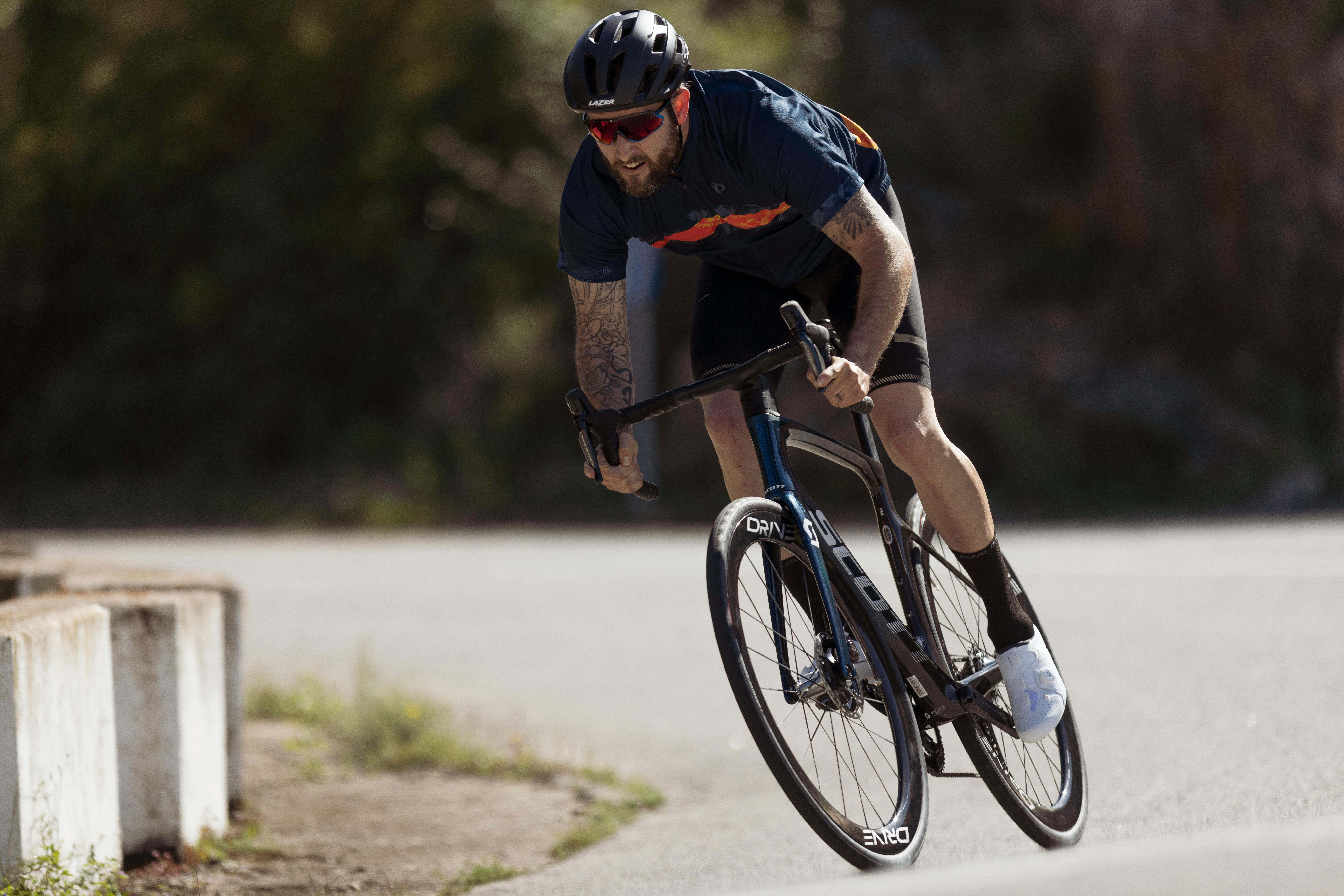 Sportsman riding bicycle on road in countryside · Free Stock Photo