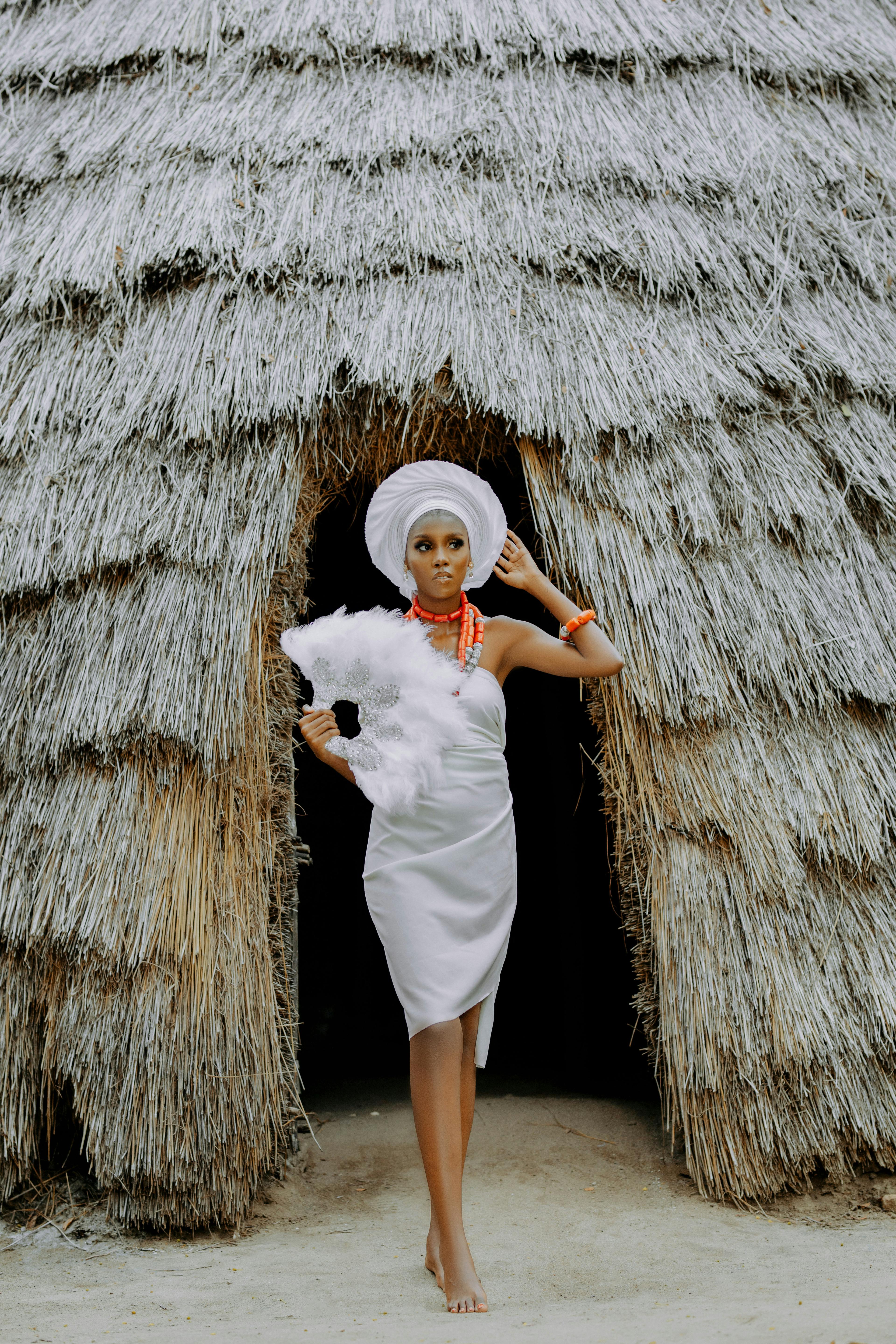 A Woman in White Dress Walking Out from a Hut · Free Stock Photo