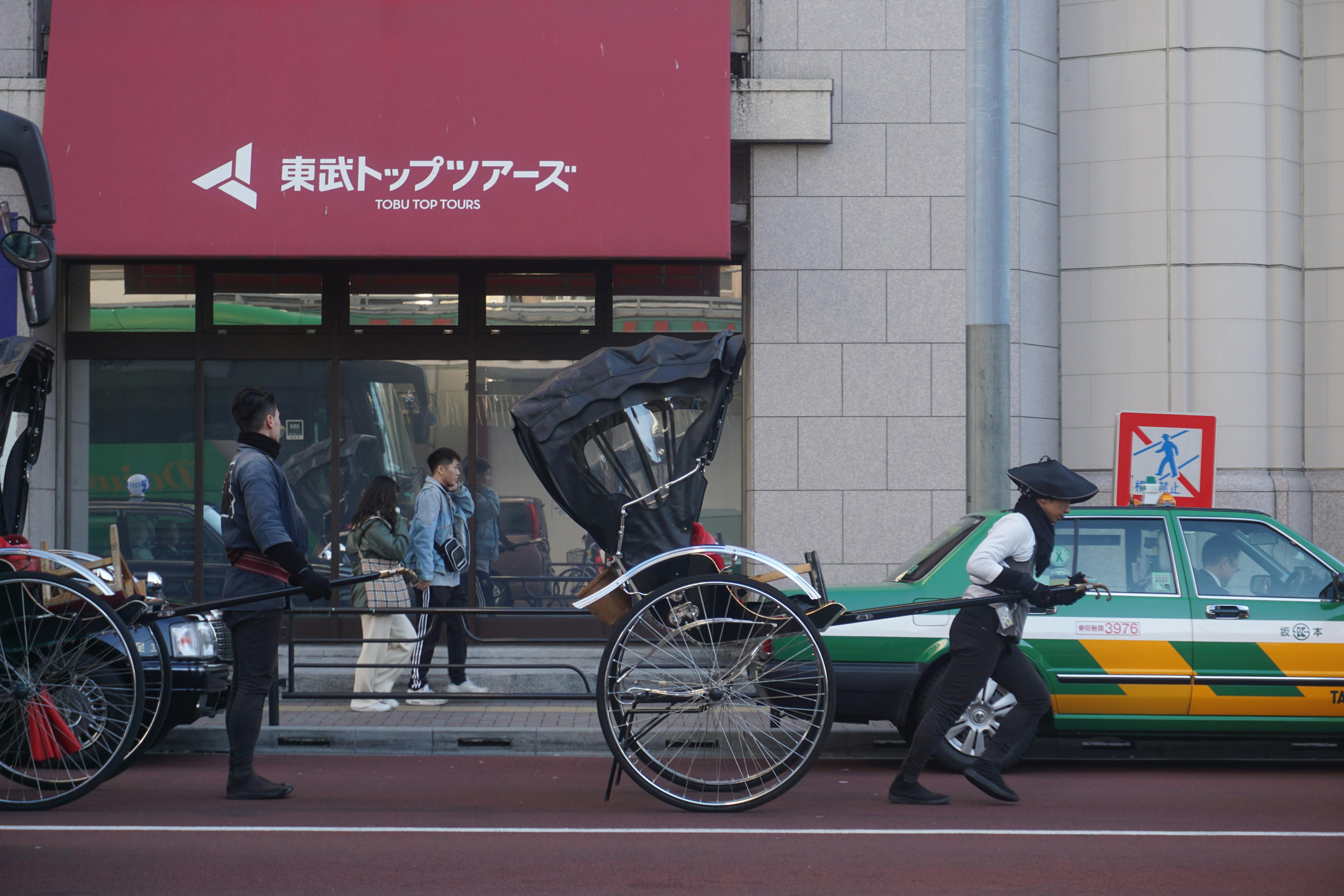 Person Pulling a Traditional Rickshaw on the Street · Free Stock Photo