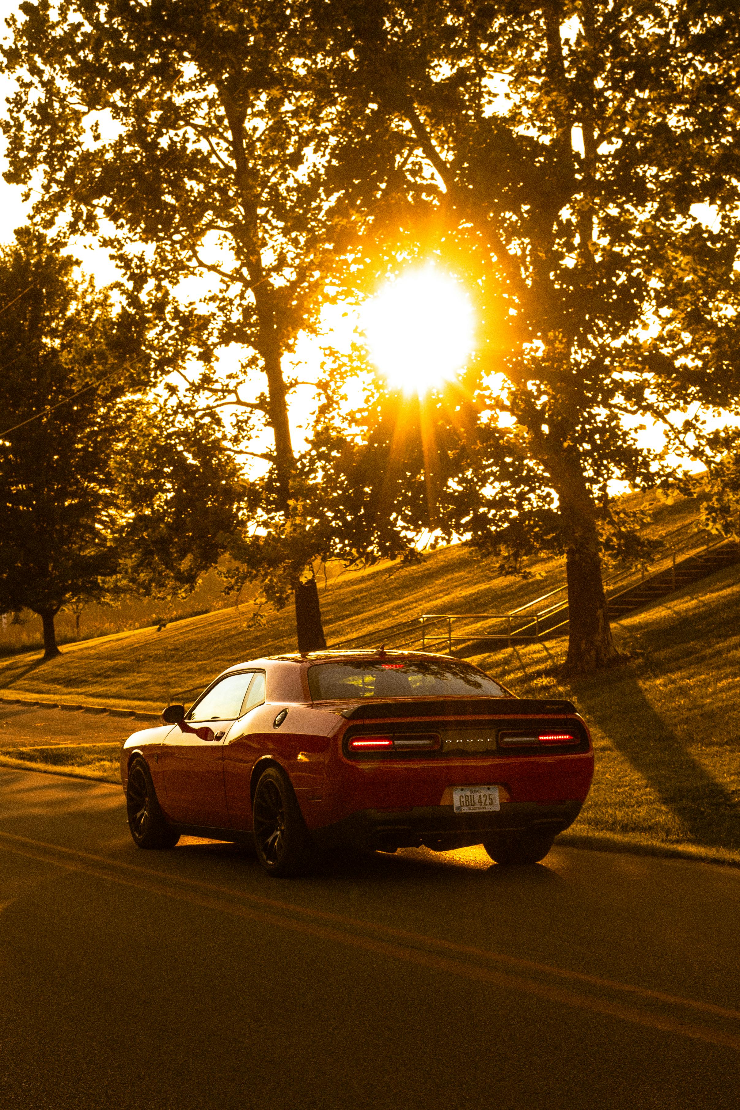 Red Sports Car on Road during Sunset · Free Stock Photo