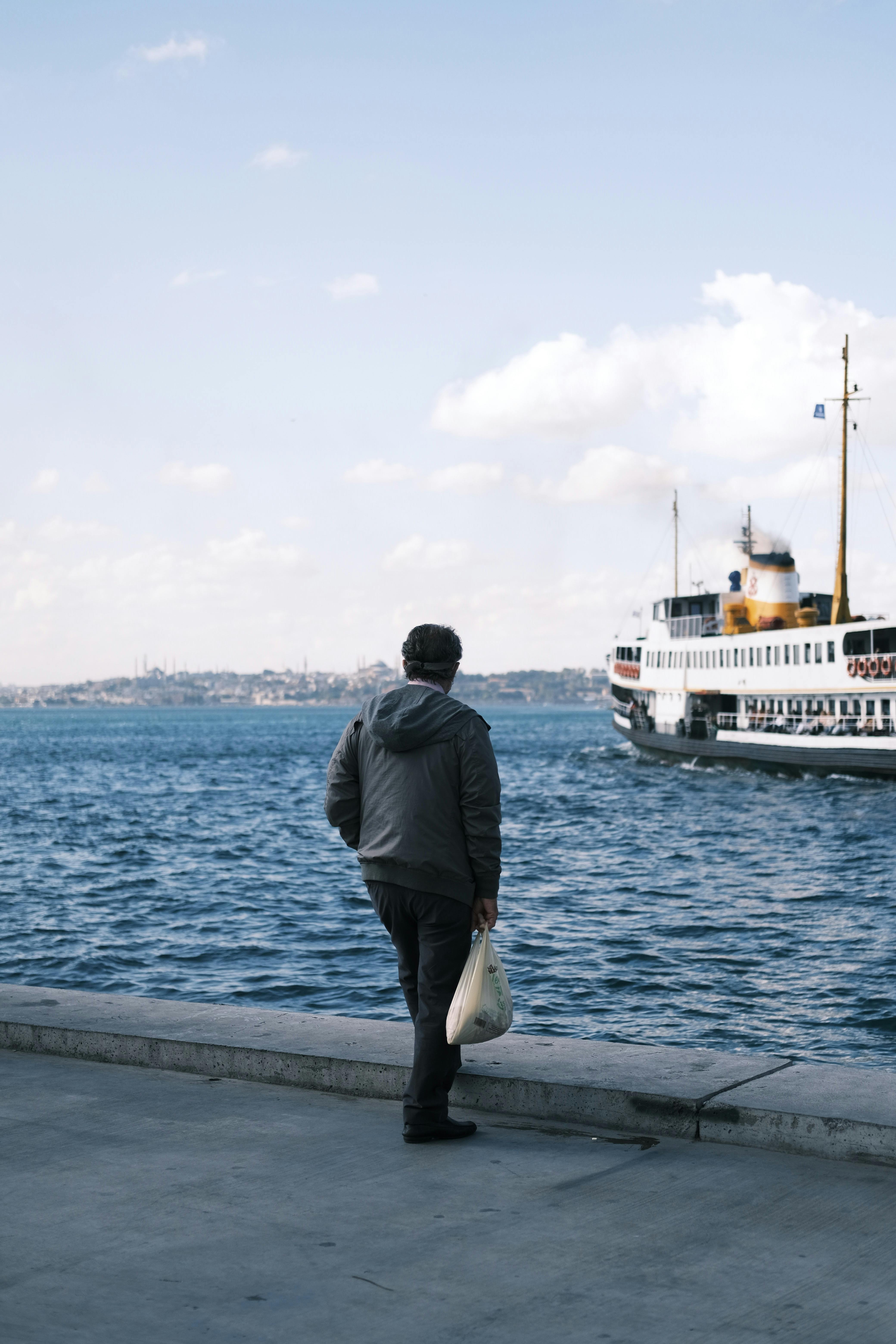 A Man in Gray Jacket Standing on Seaside · Free Stock Photo