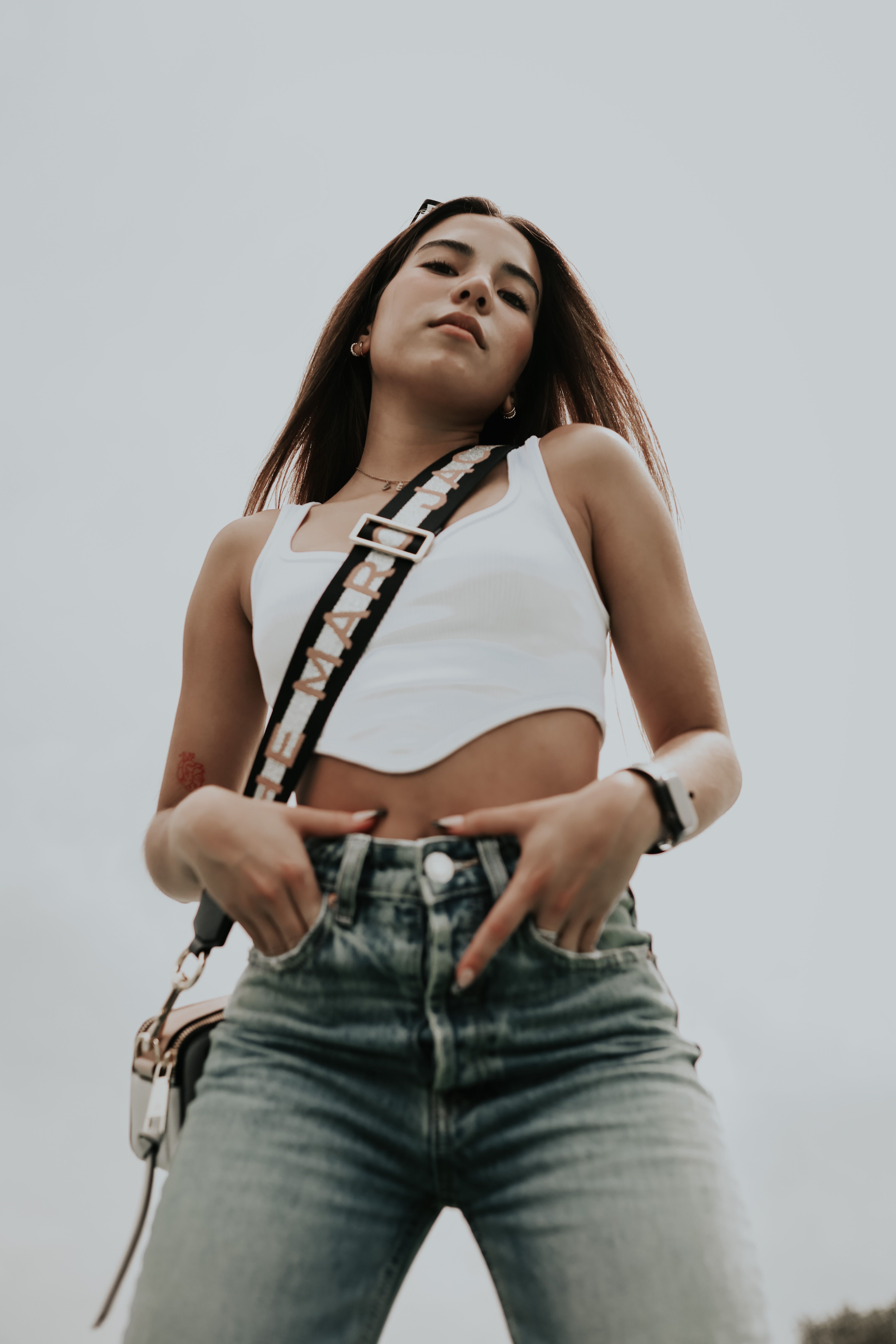 Photo of a Young Woman Standing with Hands Raised · Free Stock Photo