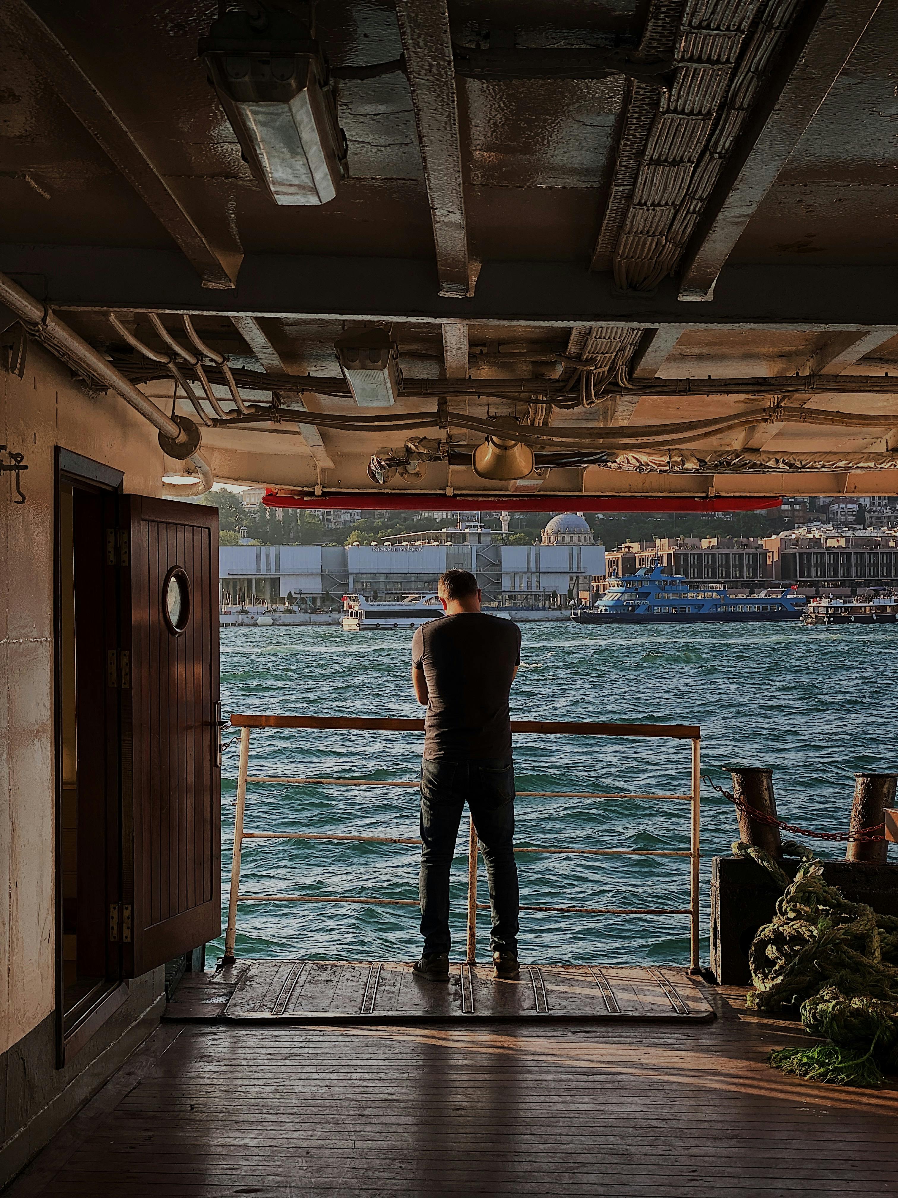 Photo of a Man Standing on the Boat Deck · Free Stock Photo
