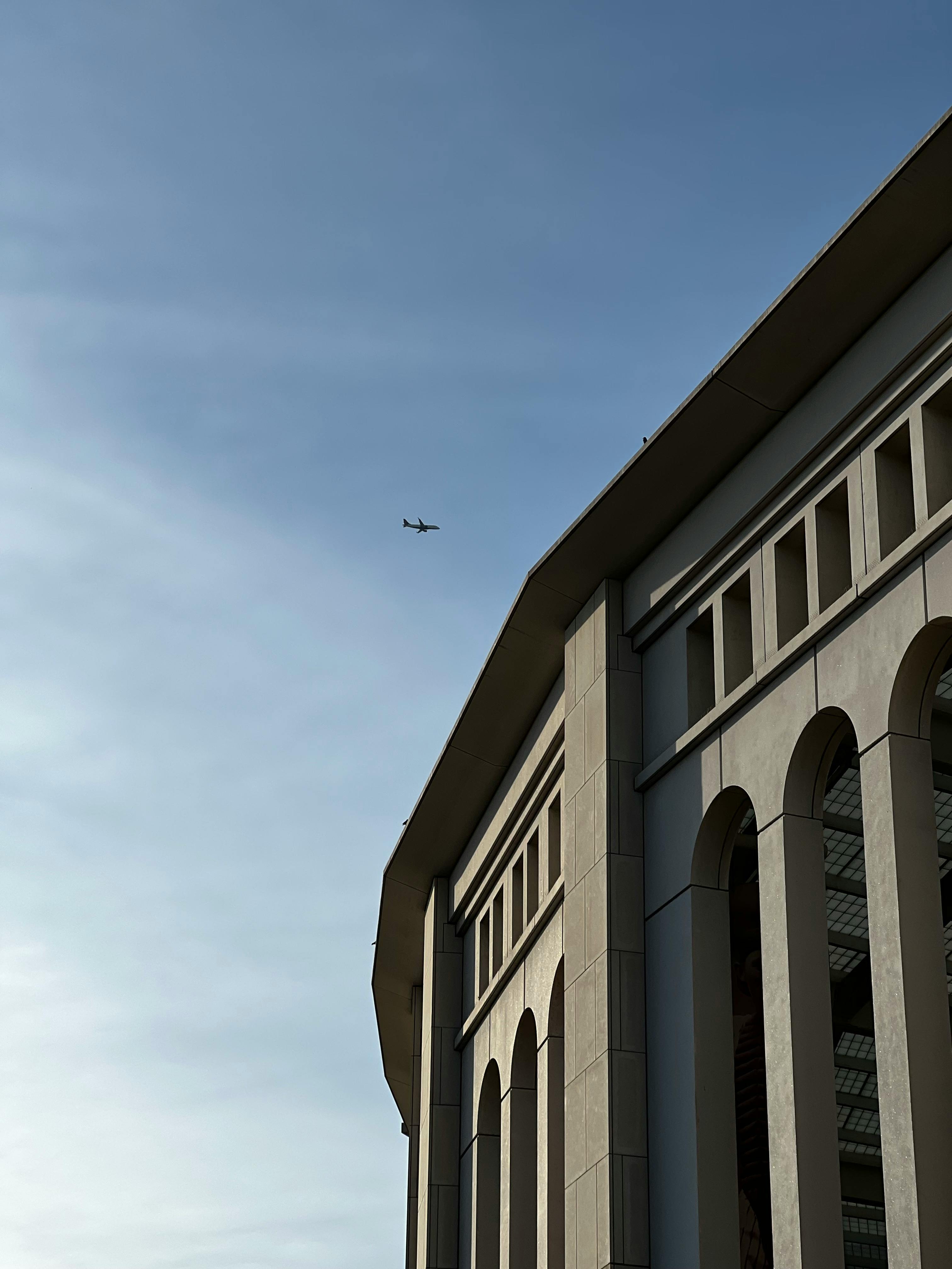 Airplane over Building · Free Stock Photo