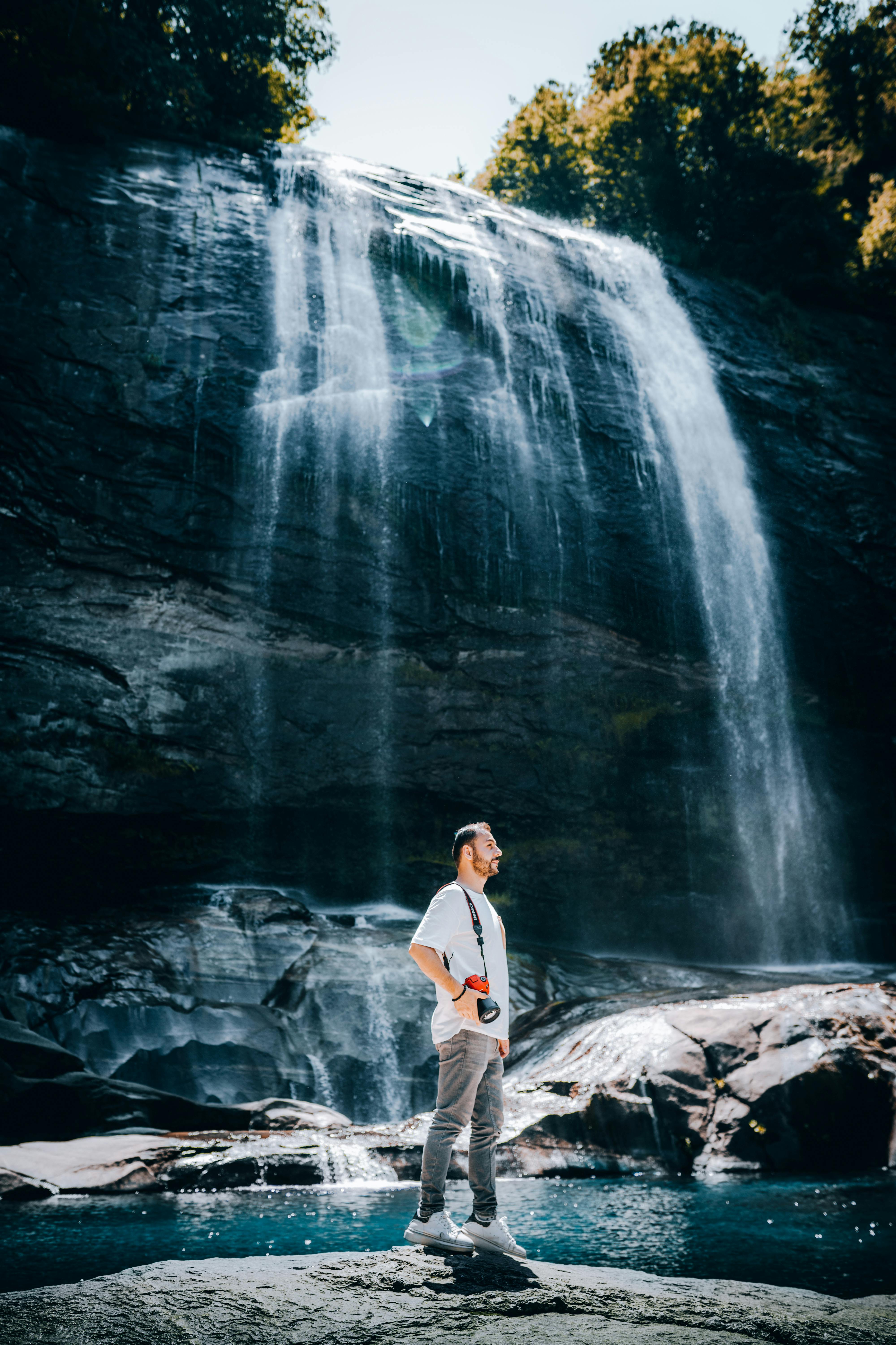 A Man in White Shirt Standing Beside the Waterfalls · Free Stock Photo