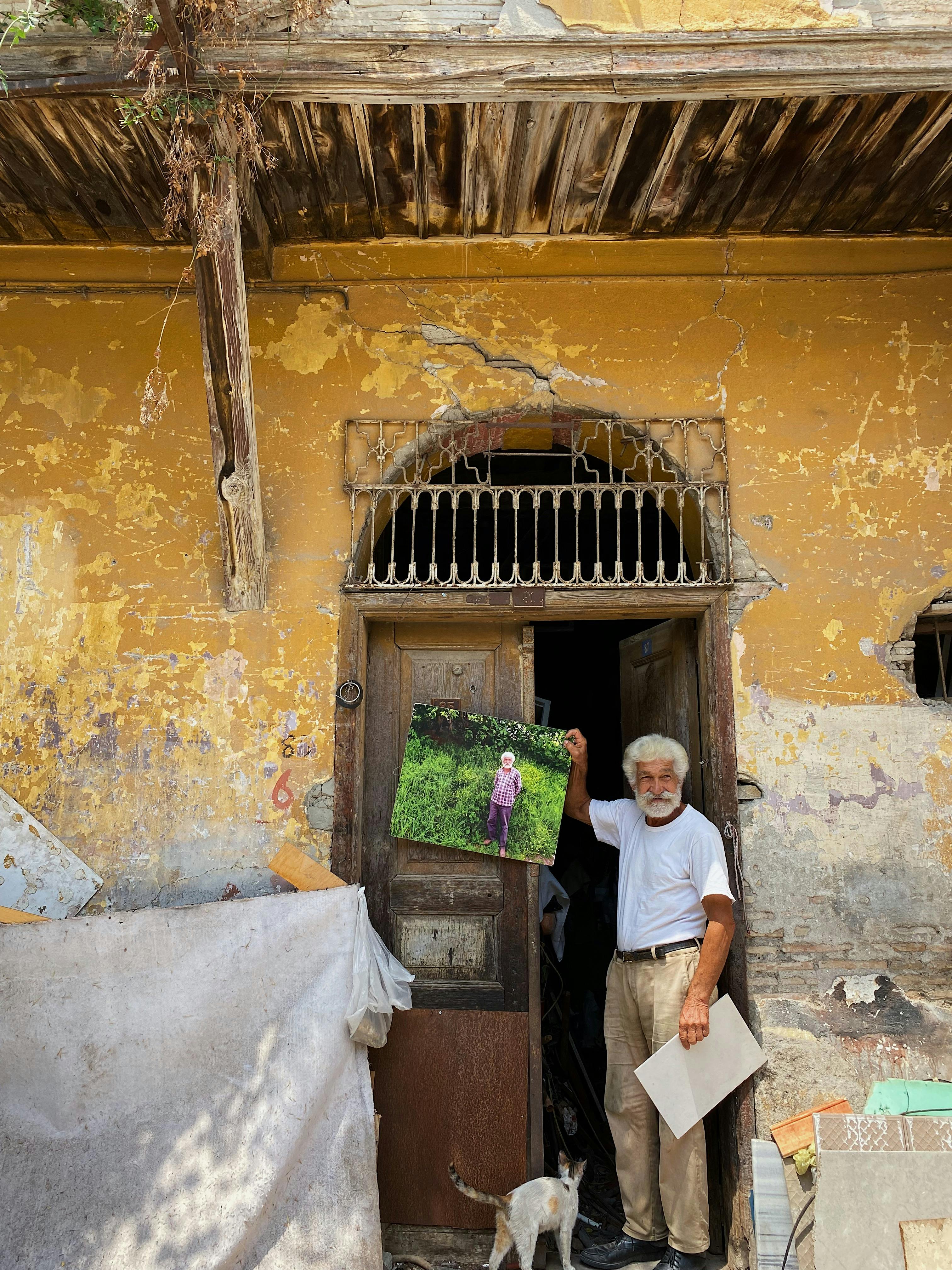 Old Man Standing near Building Wooden Doors · Free Stock Photo