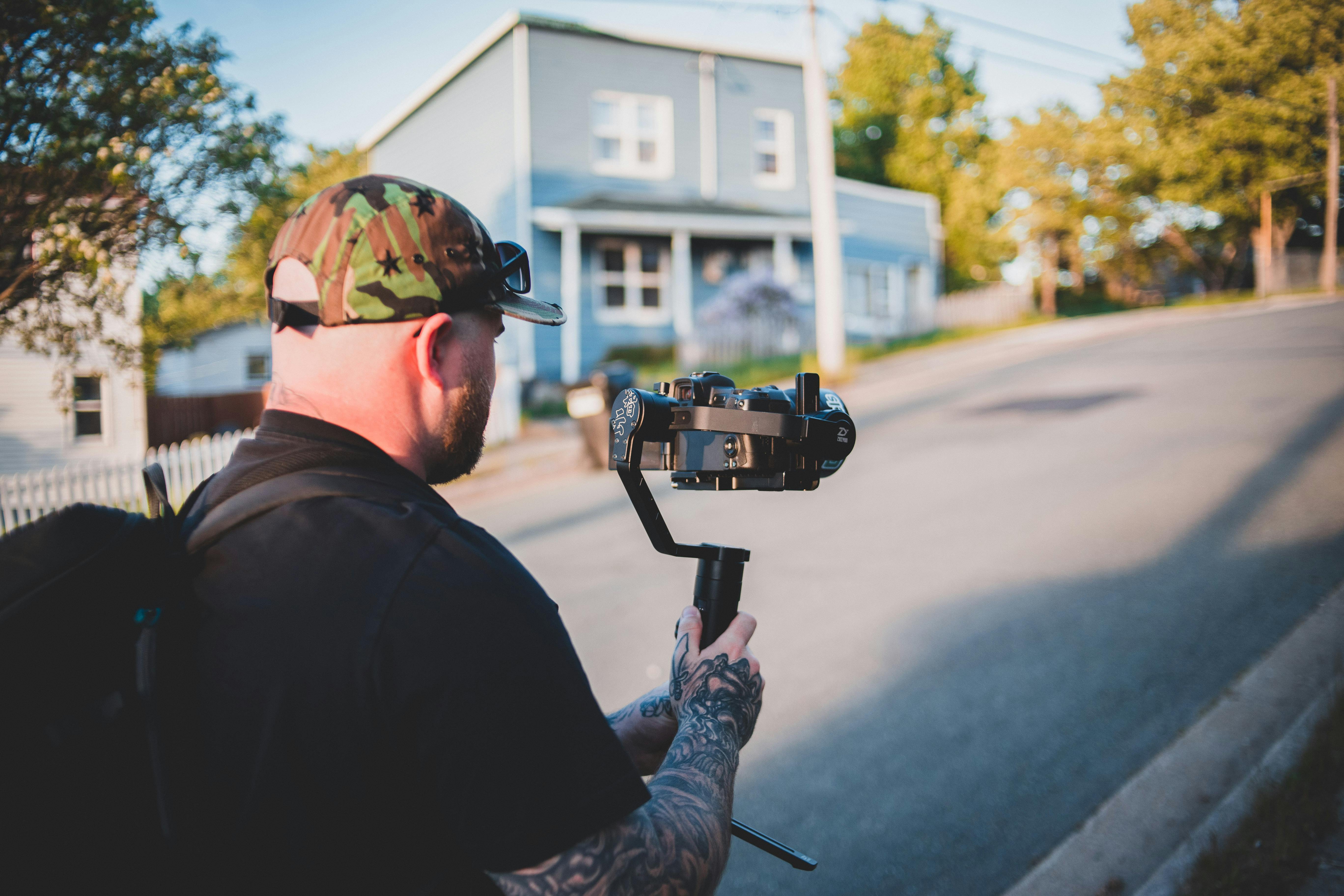 Photo of Man Standing in Alley Holding Dslr Camera Looking at Photos ...