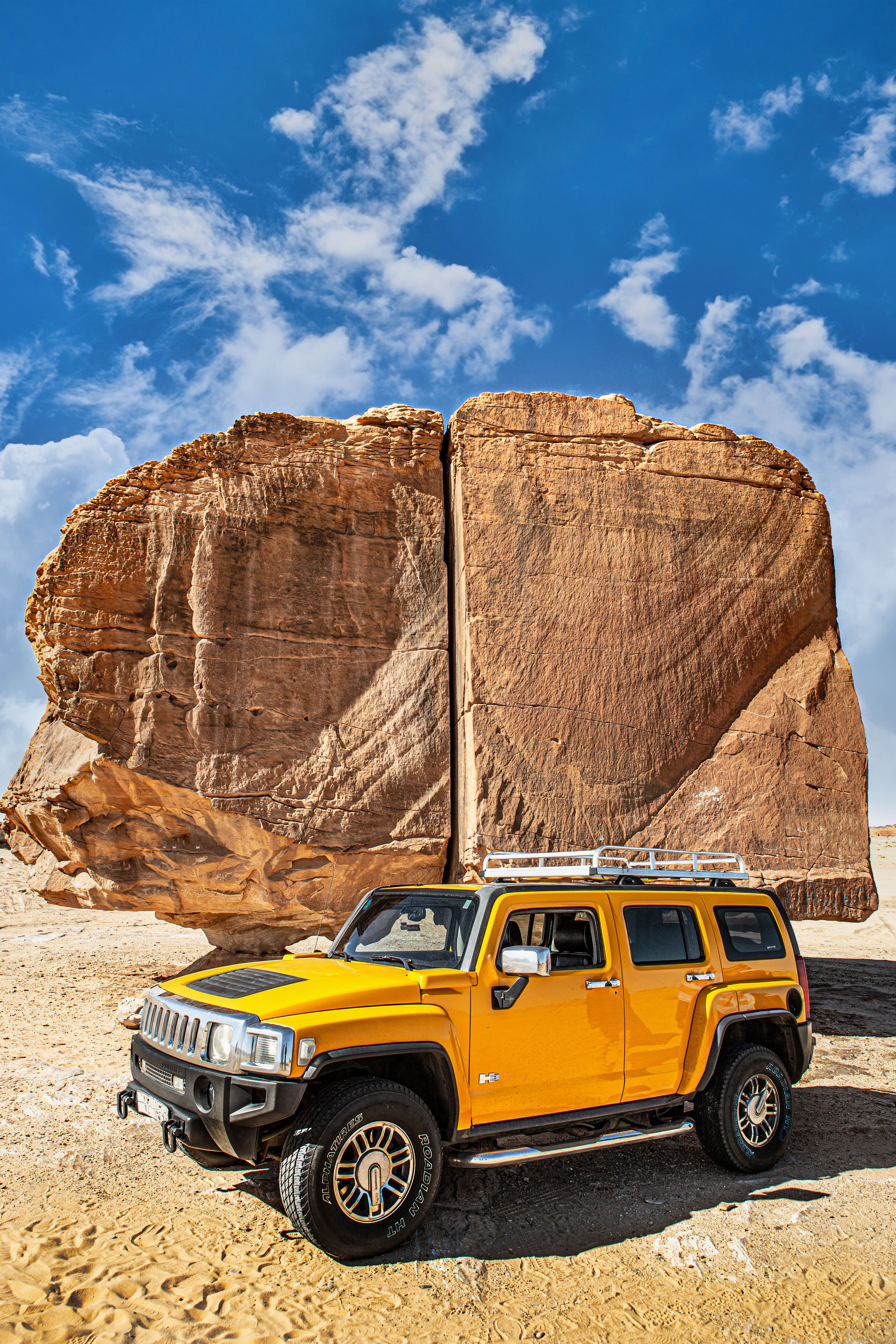 Yellow and Black SUV Near Brown Rock Formation · Free Stock Photo