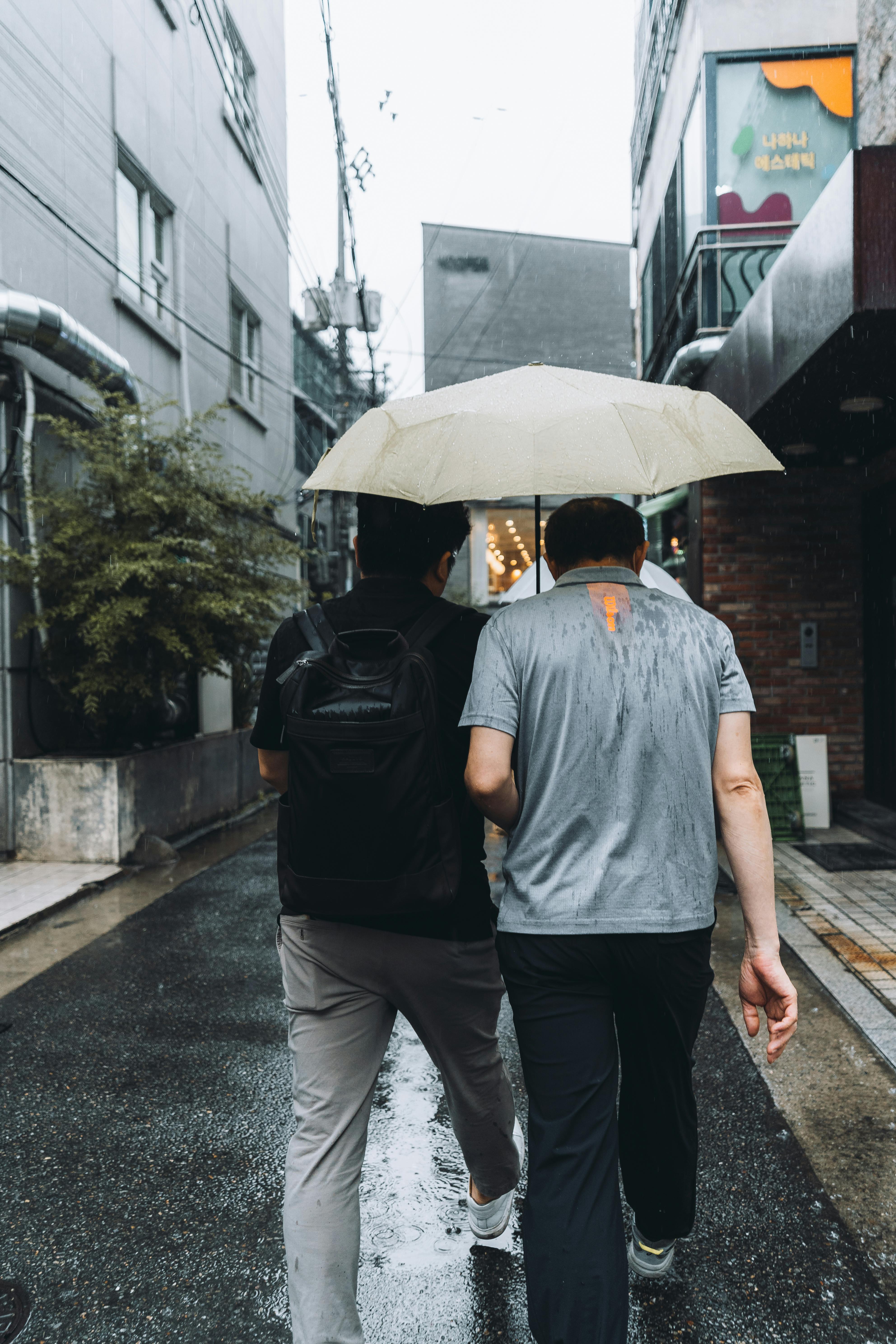 Men Walking While Raining · Free Stock Photo