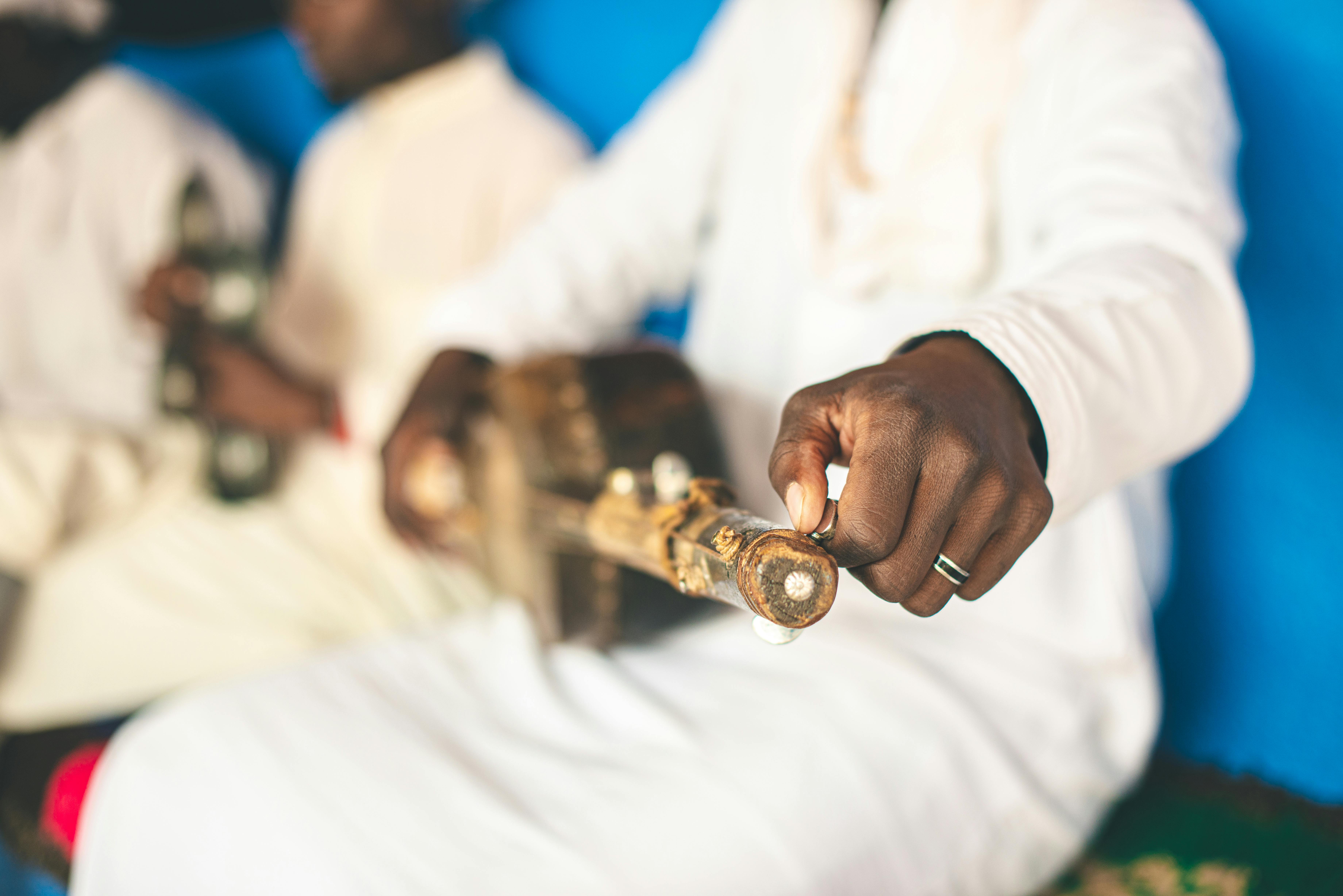 Man Wearing Blue Top Holding Brown String Instrument · Free Stock Photo