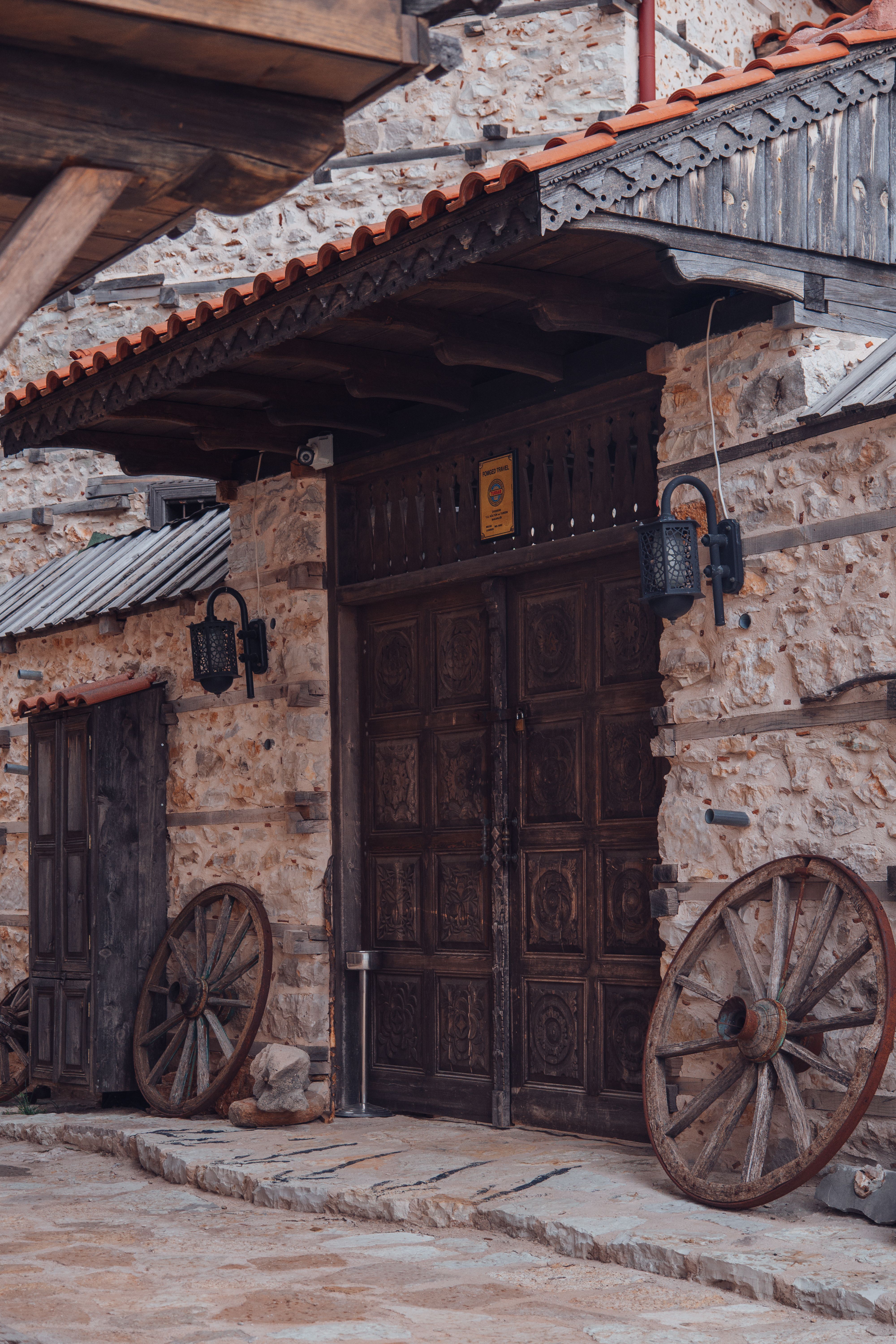Wooden Entrance Door with Cart Wheels · Free Stock Photo