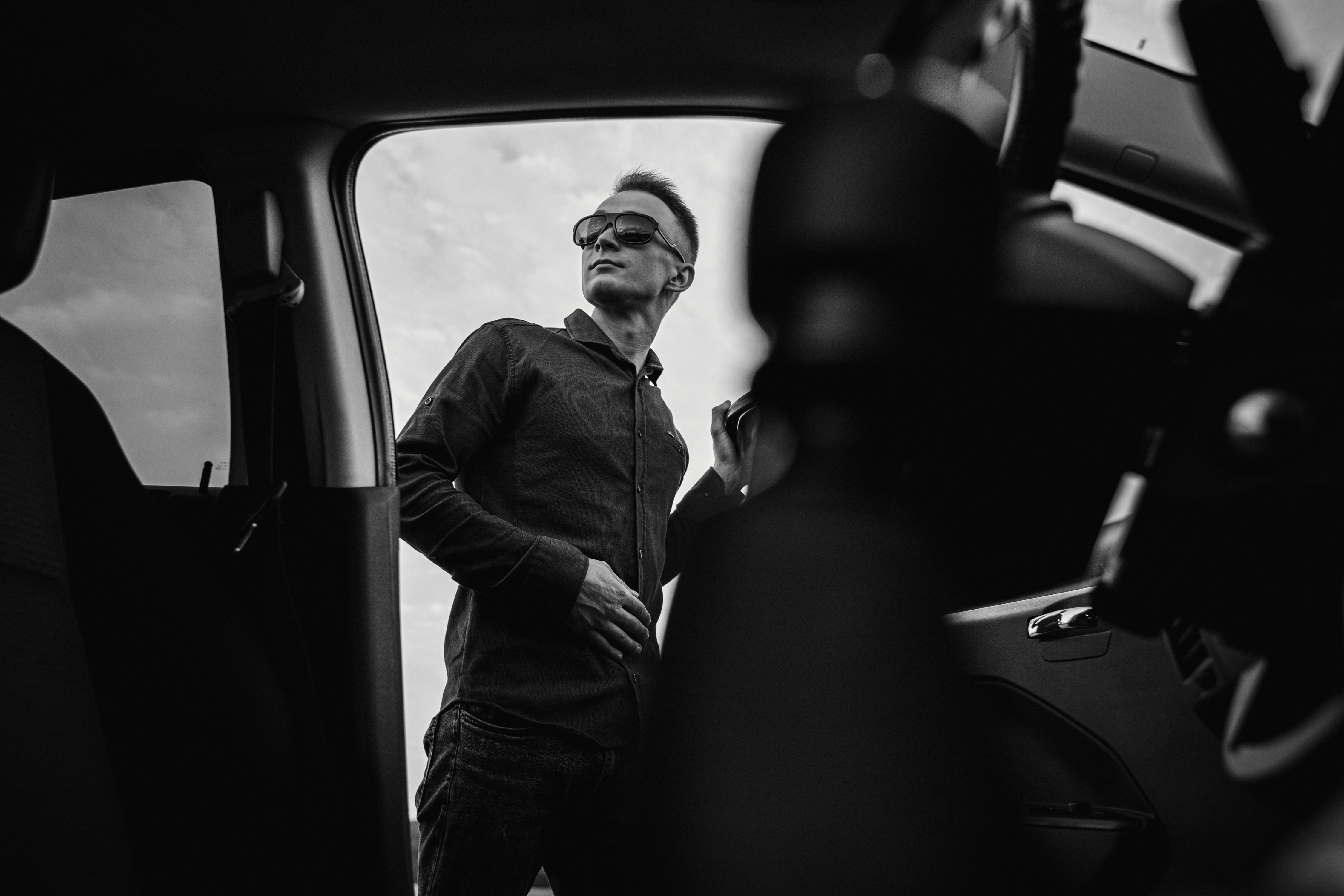 Grayscale Photograph of a Man Getting Out of a Car · Free Stock Photo