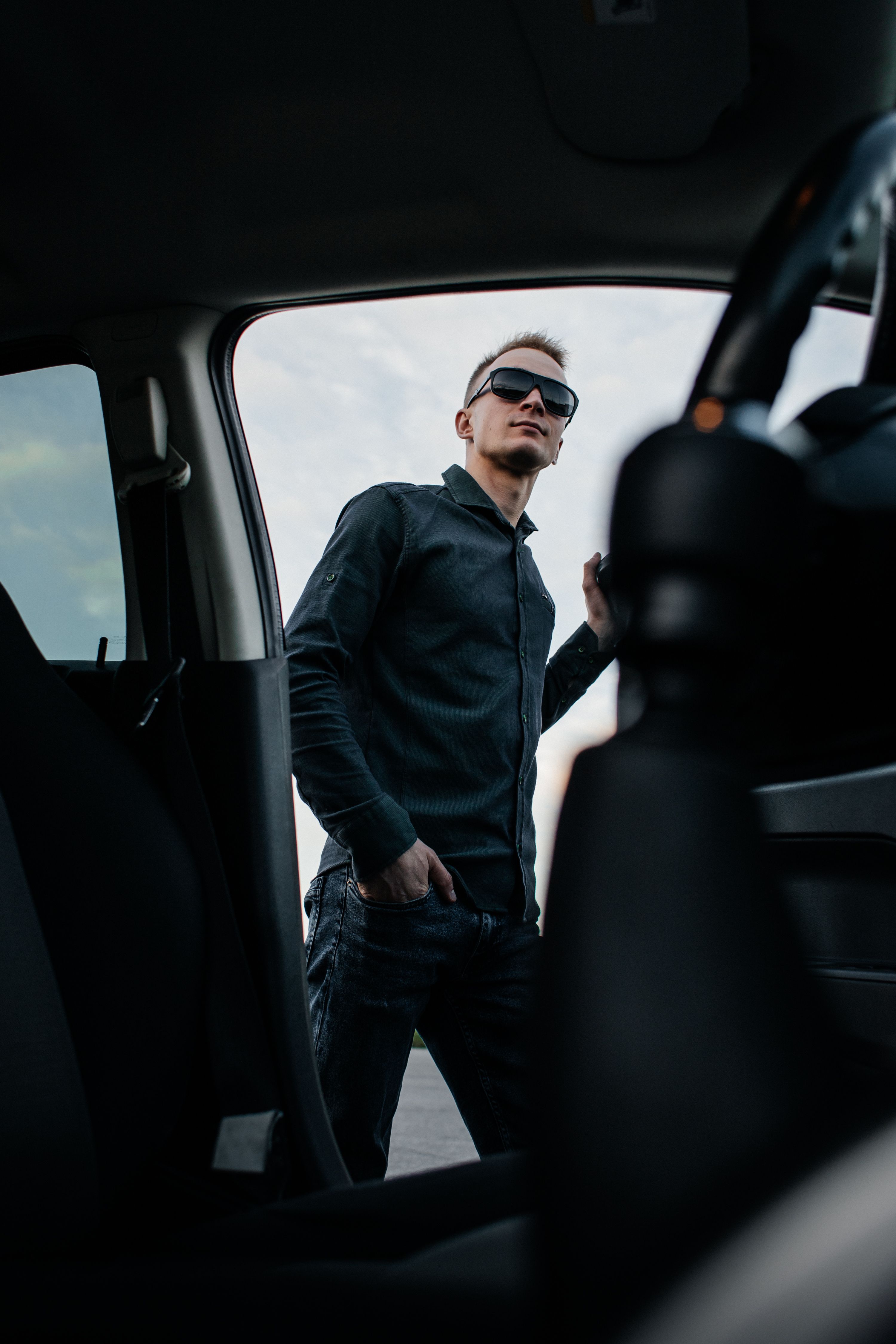 Man Wearing Button Up Shirt Leaning on a Car Door · Free Stock Photo