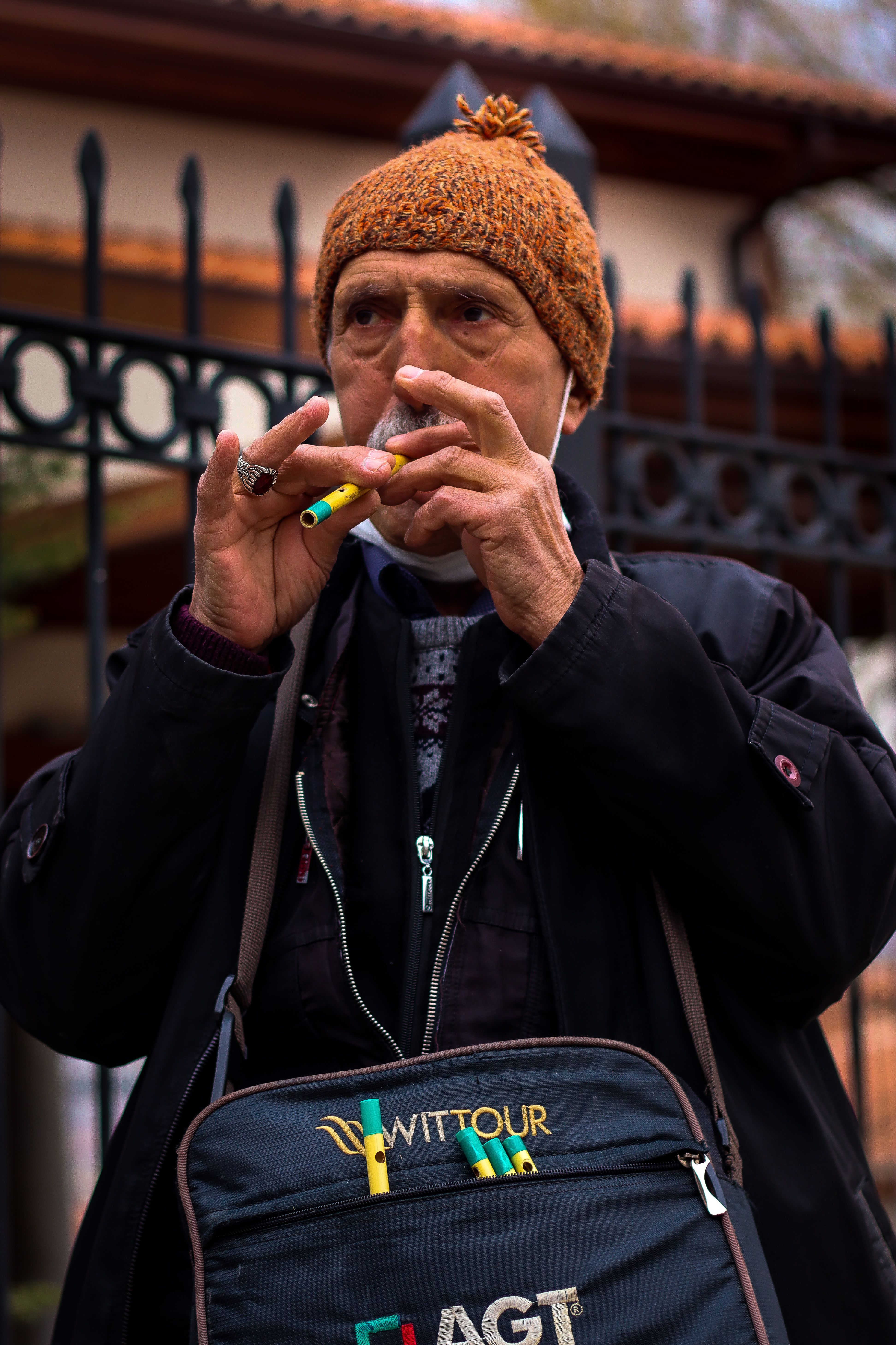 A Man with a Brown Bonnet Playing the Flute · Free Stock Photo