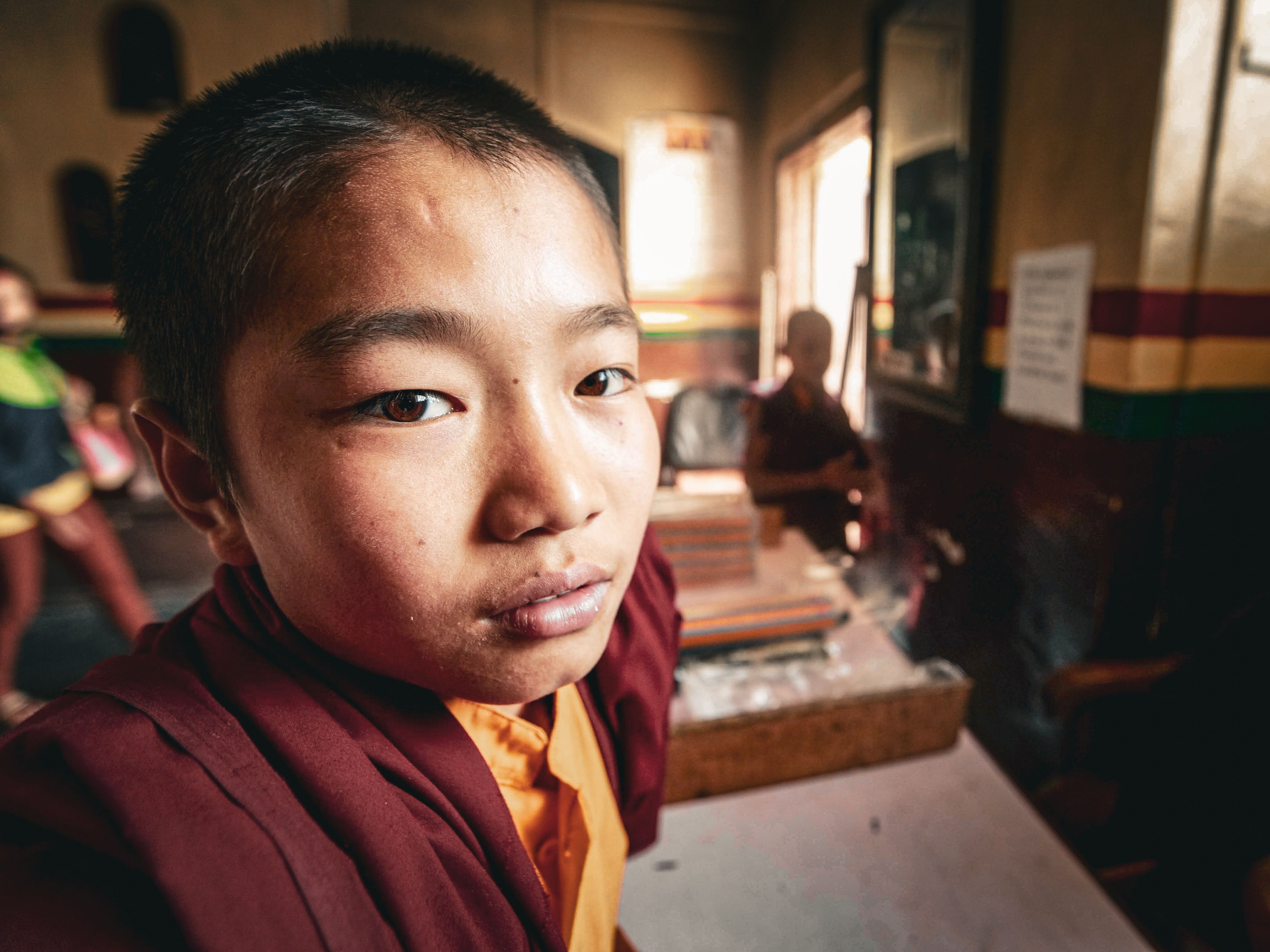 Little Boy in Monk Robes Leaning Against Pillar · Free Stock Photo