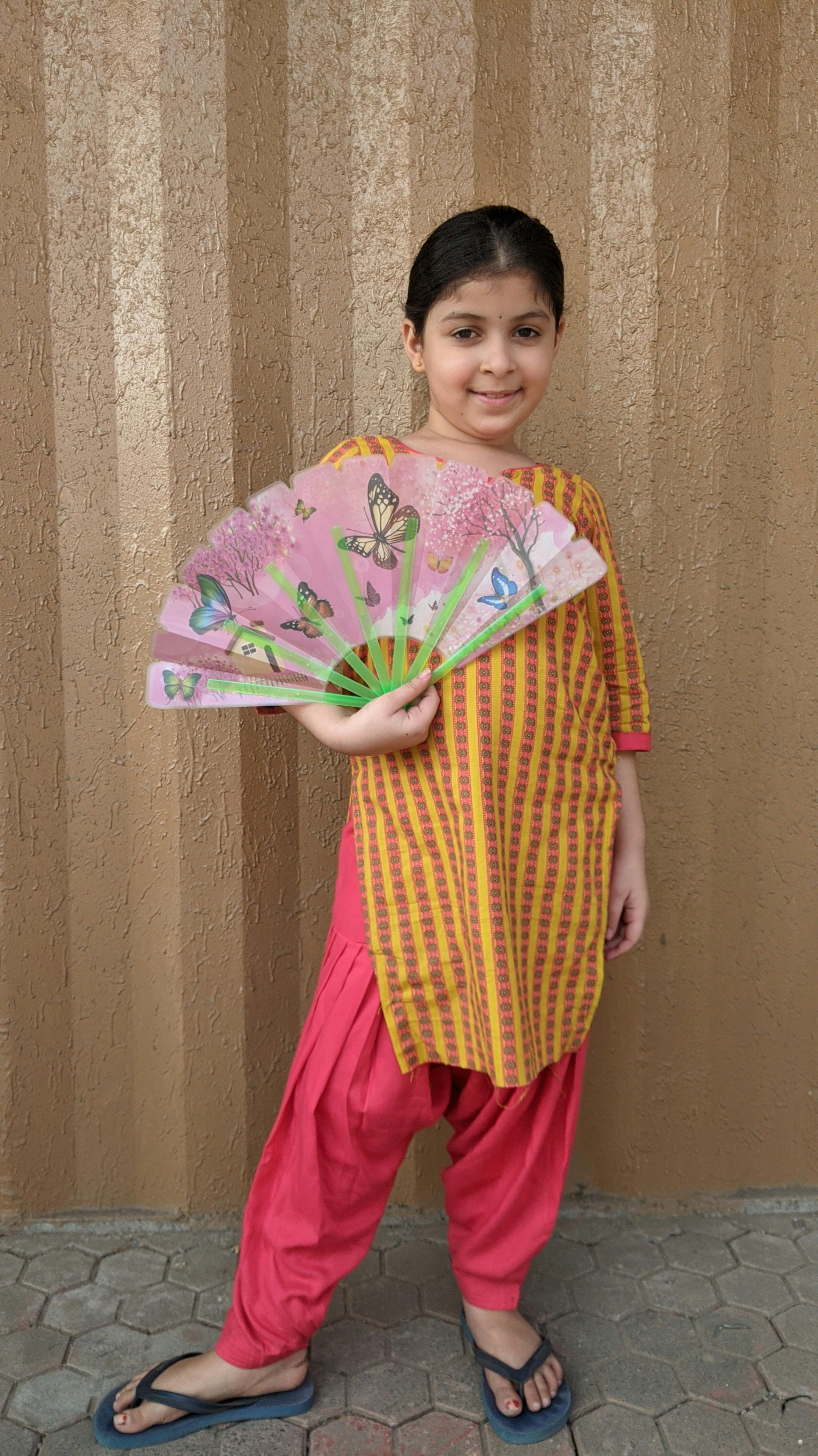 A Girl Holding a Folding Fan · Free Stock Photo