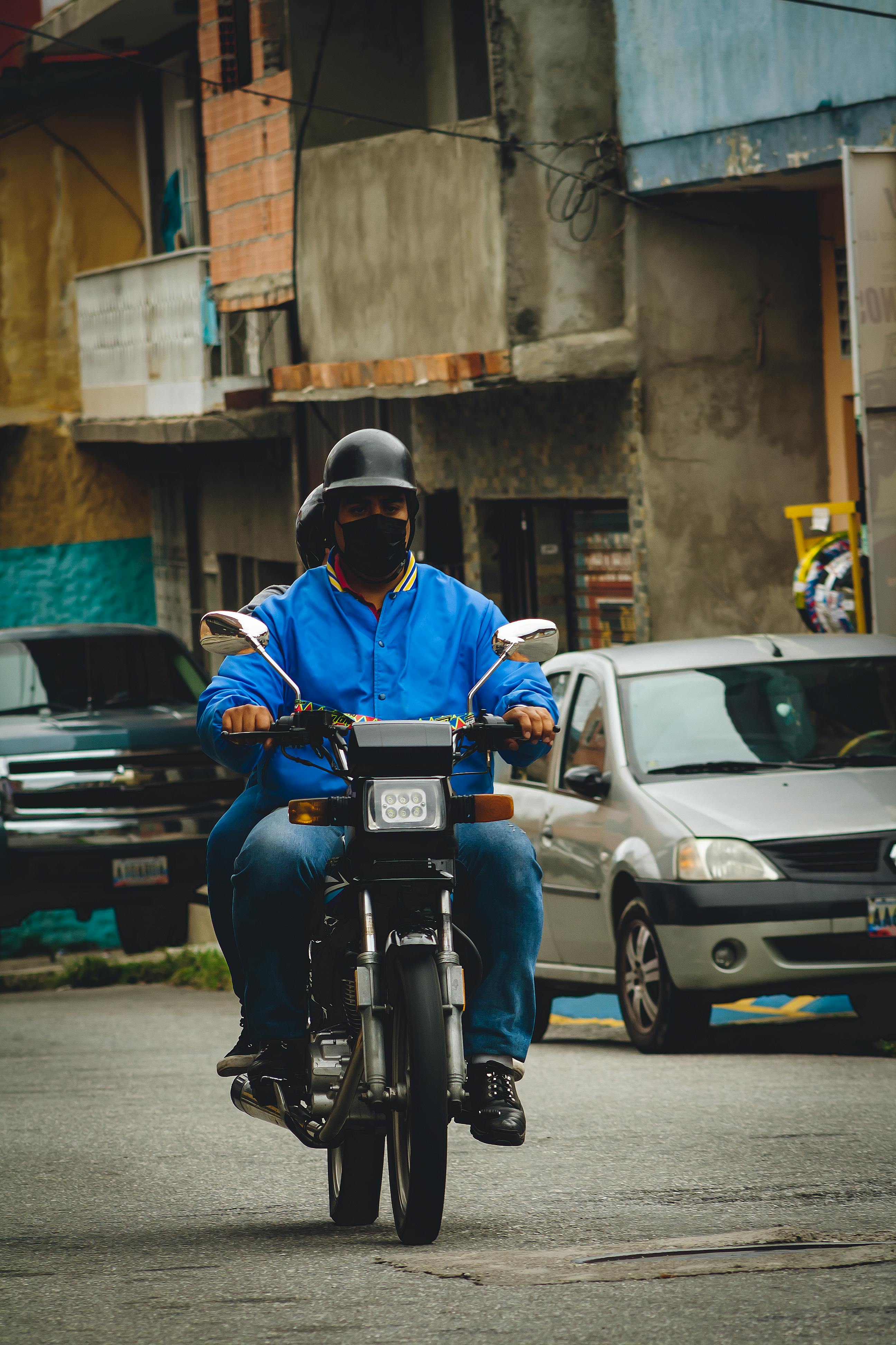A Delivery Man Riding a Motorcycle on Road · Free Stock Photo