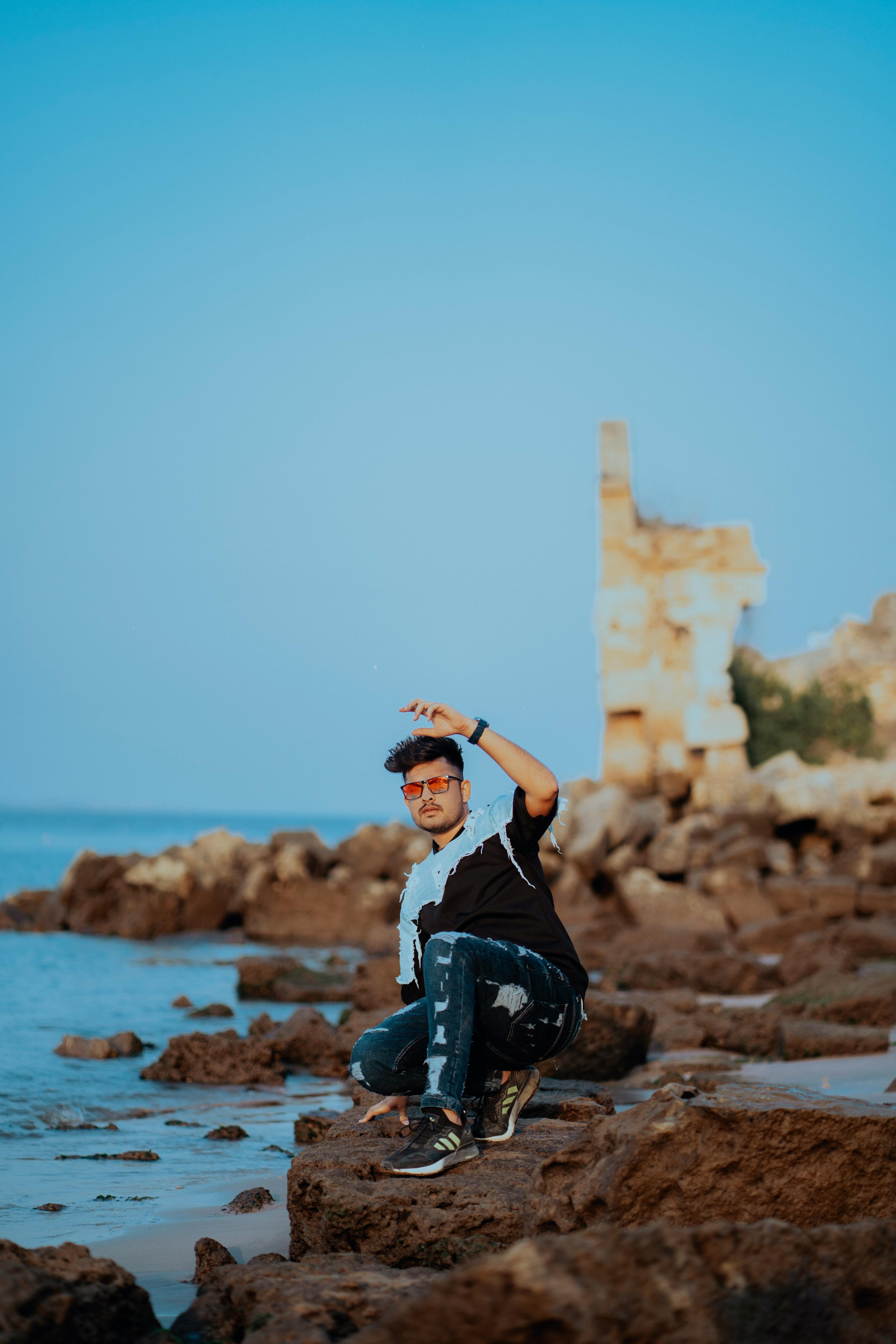 Man Crouching on a Rock · Free Stock Photo