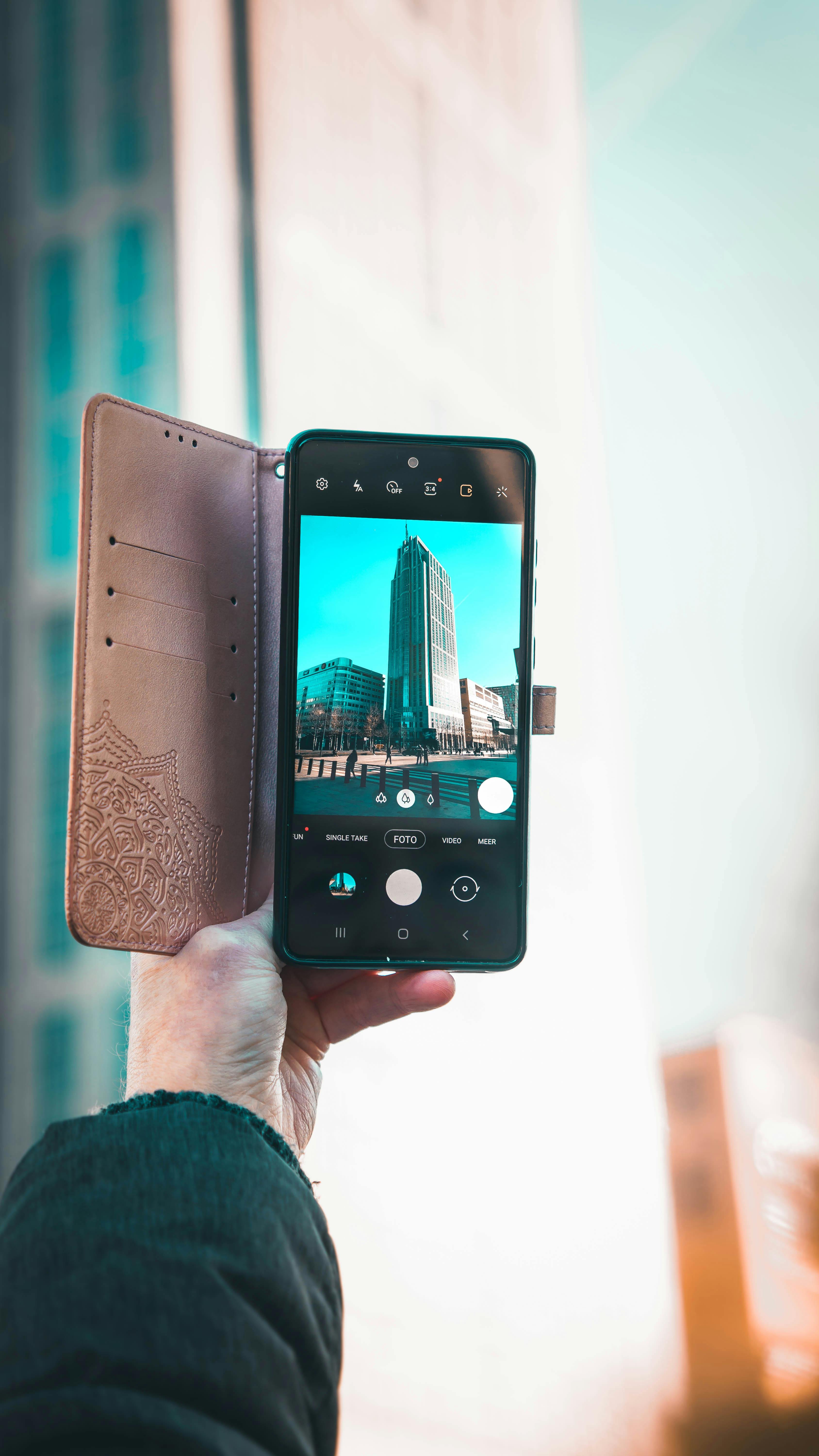 A Person Holding a Smartphone while Taking Photo · Free Stock Photo