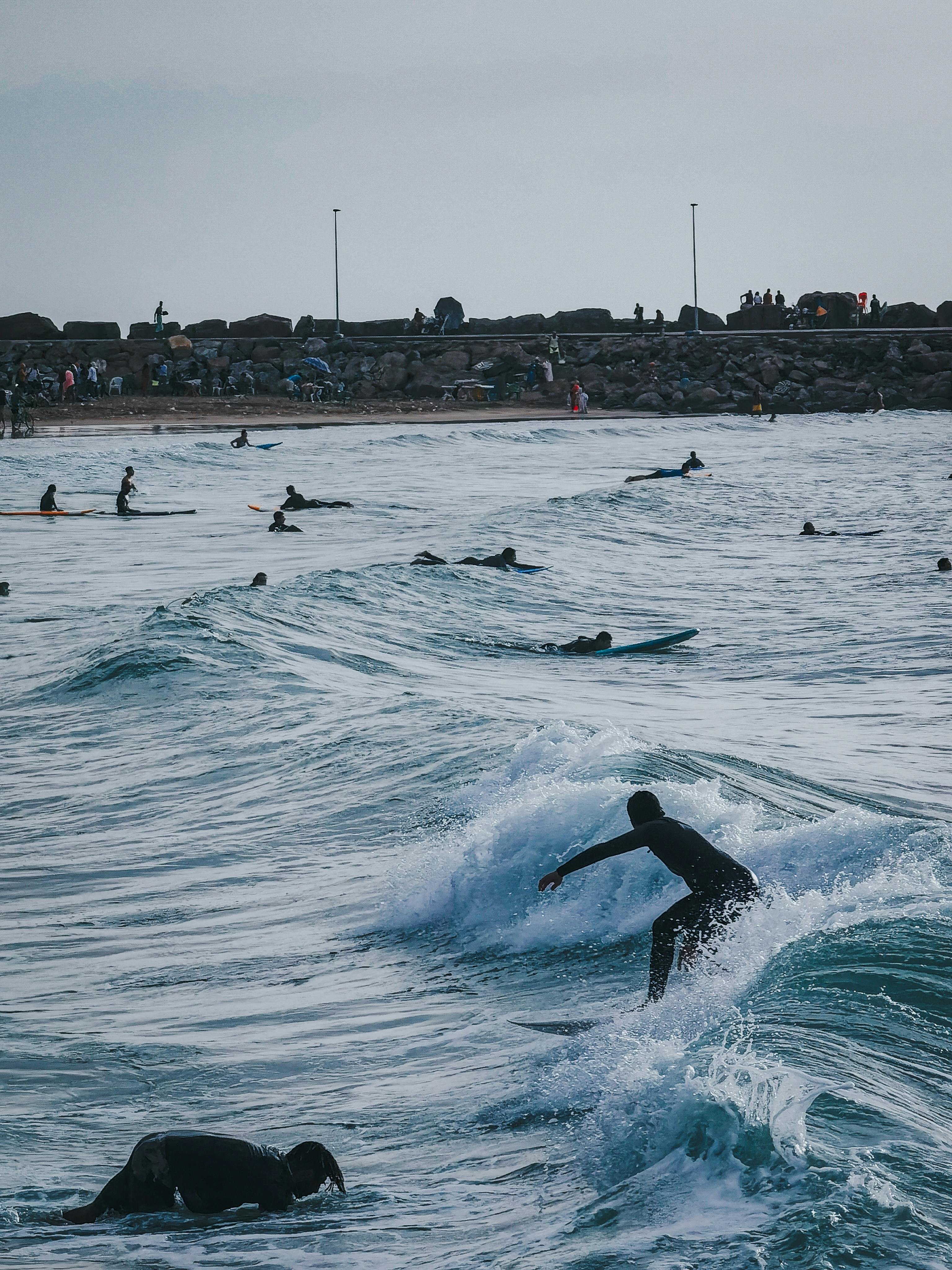 Photo of People Surfing on Sea Waves · Free Stock Photo