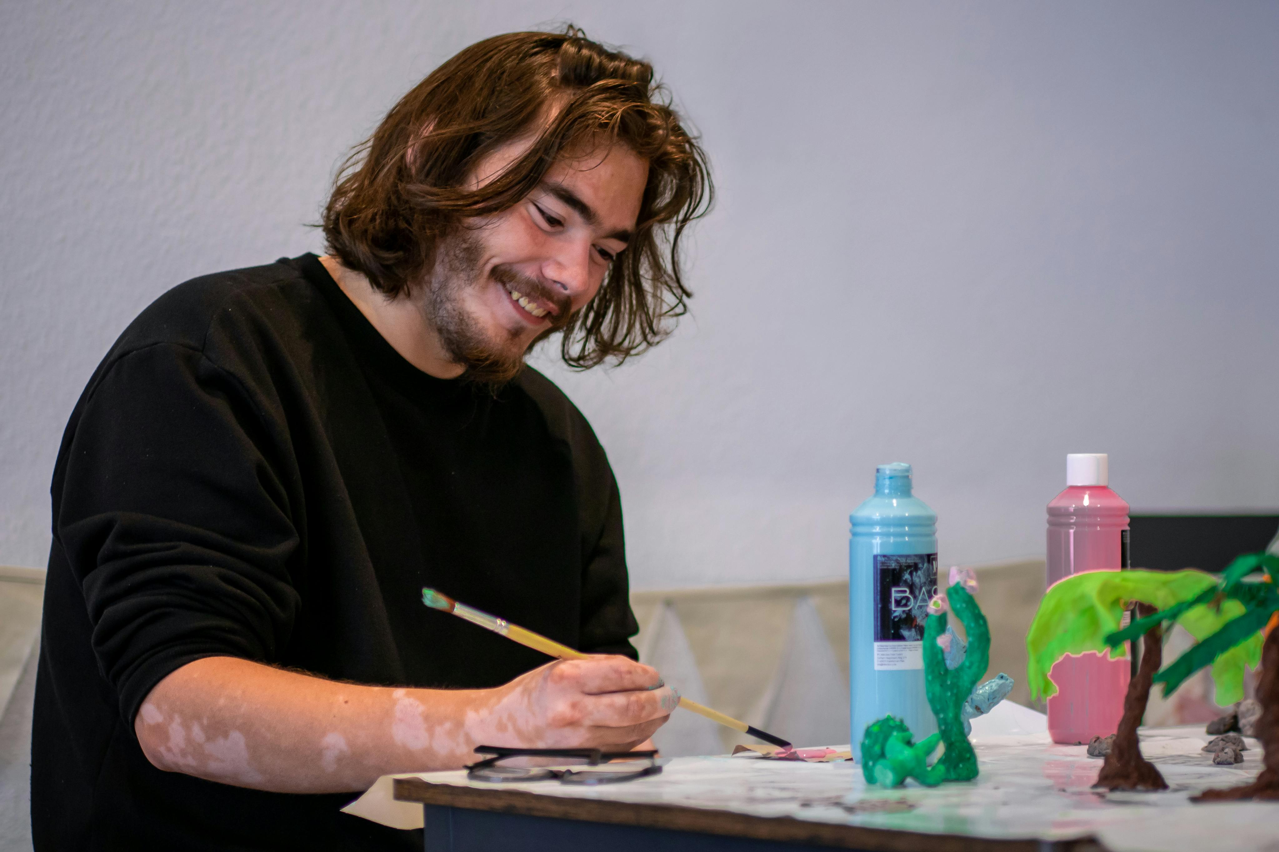 A Man Painting while Smiling · Free Stock Photo