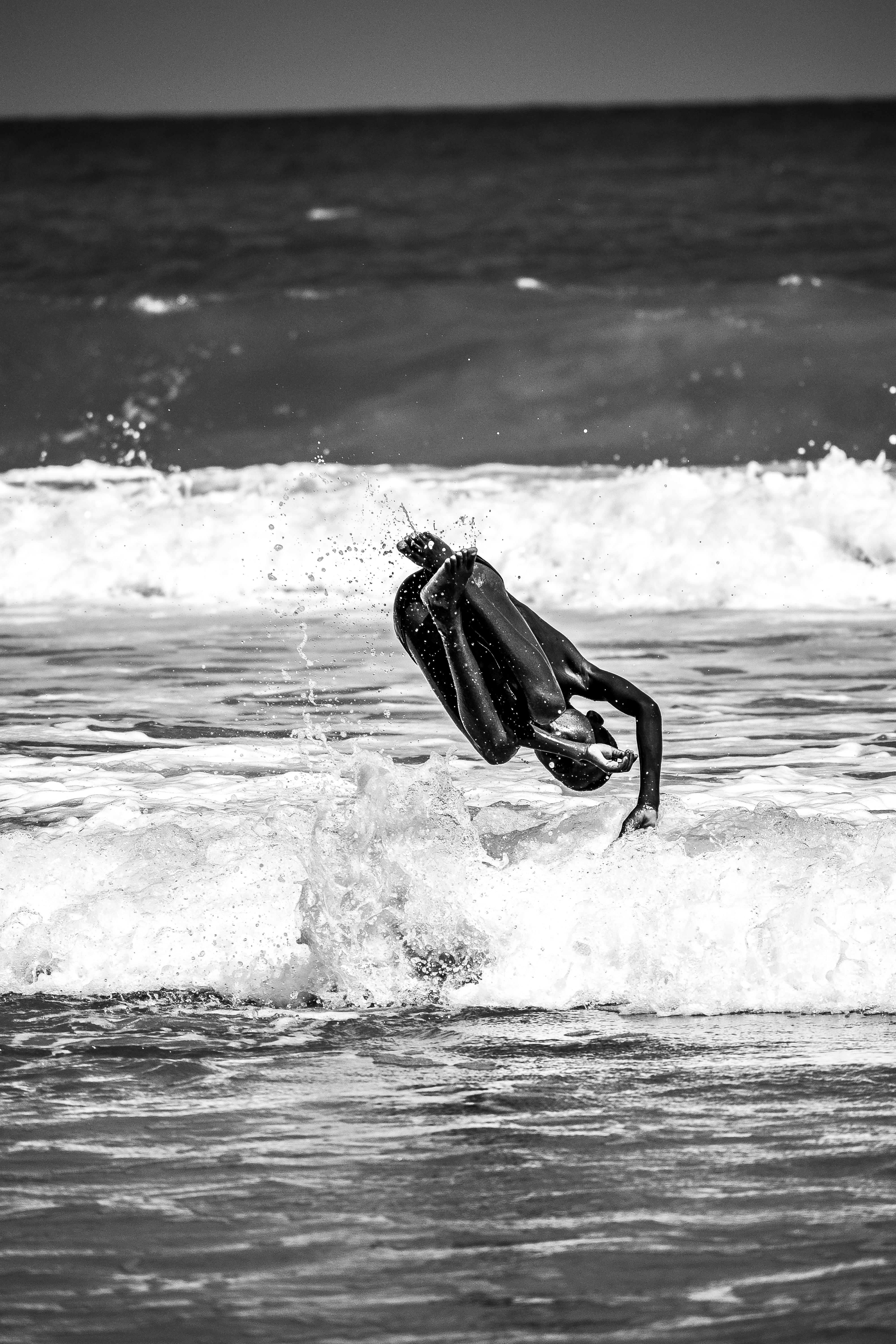 Grayscale Photo of a Kid Diving into the Sea · Free Stock Photo