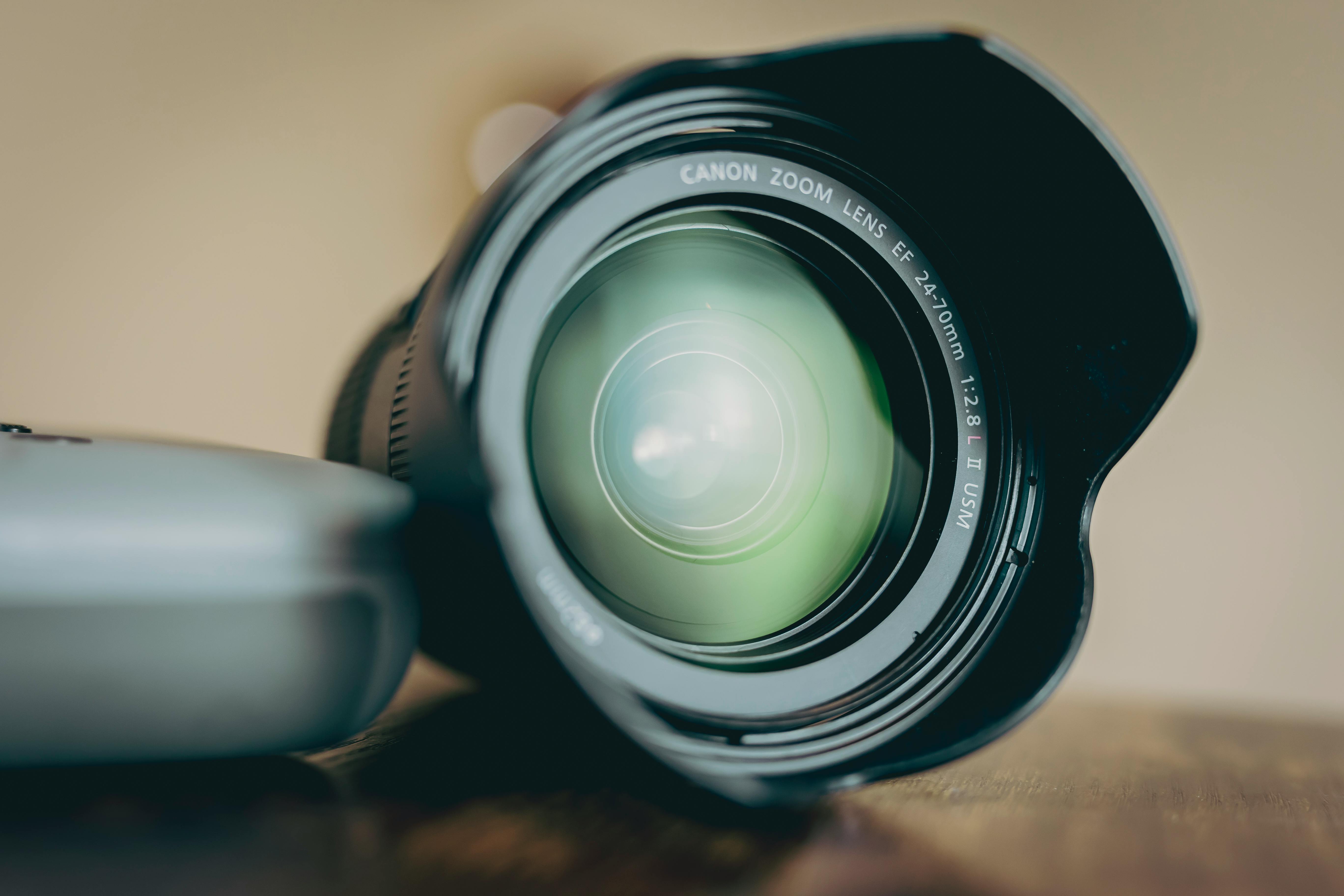 A Close-up Shot of a Camera Lens on Wooden Table · Free Stock Photo