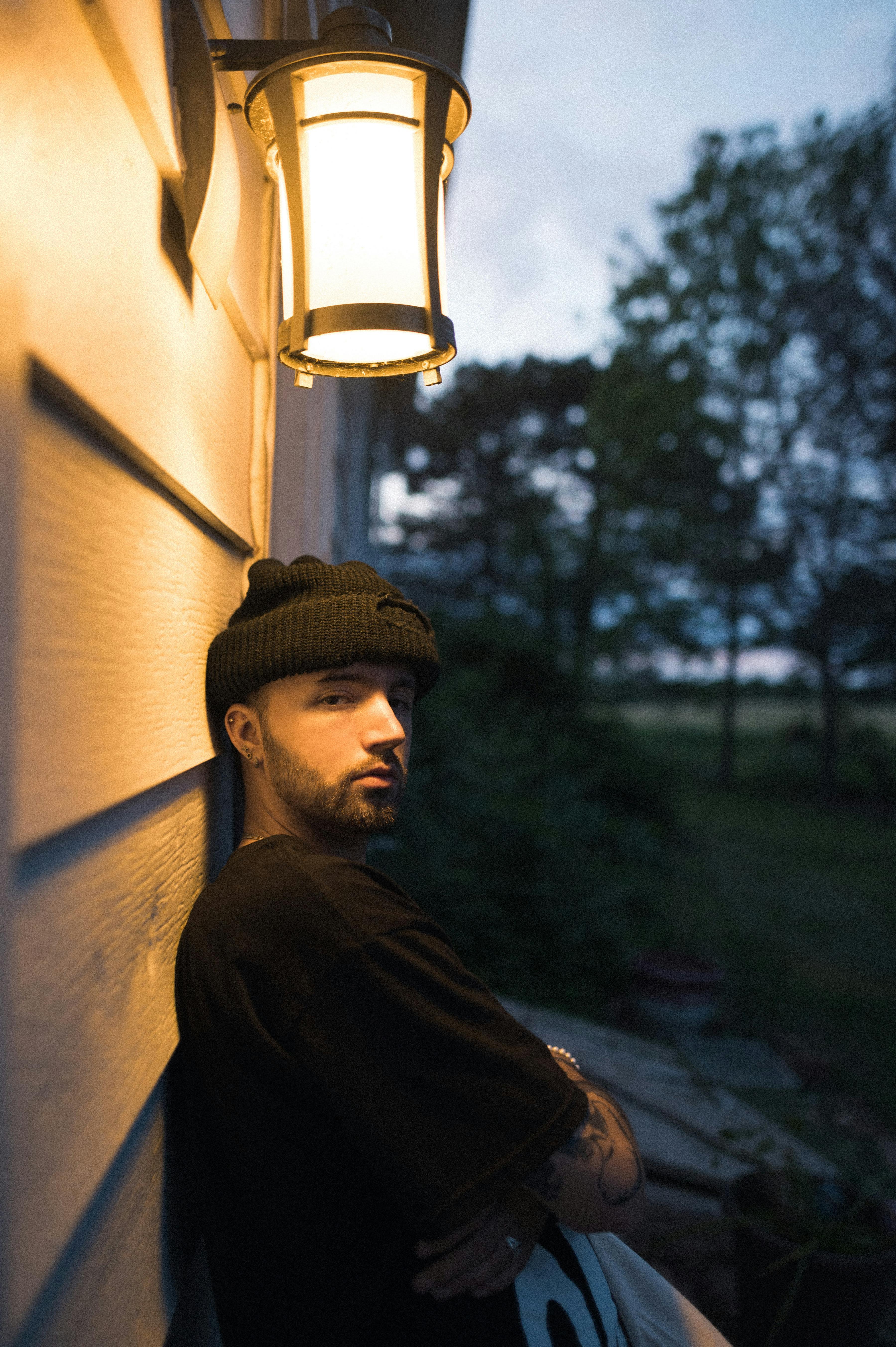 Young Man Standing and Leaning against a Building · Free Stock Photo