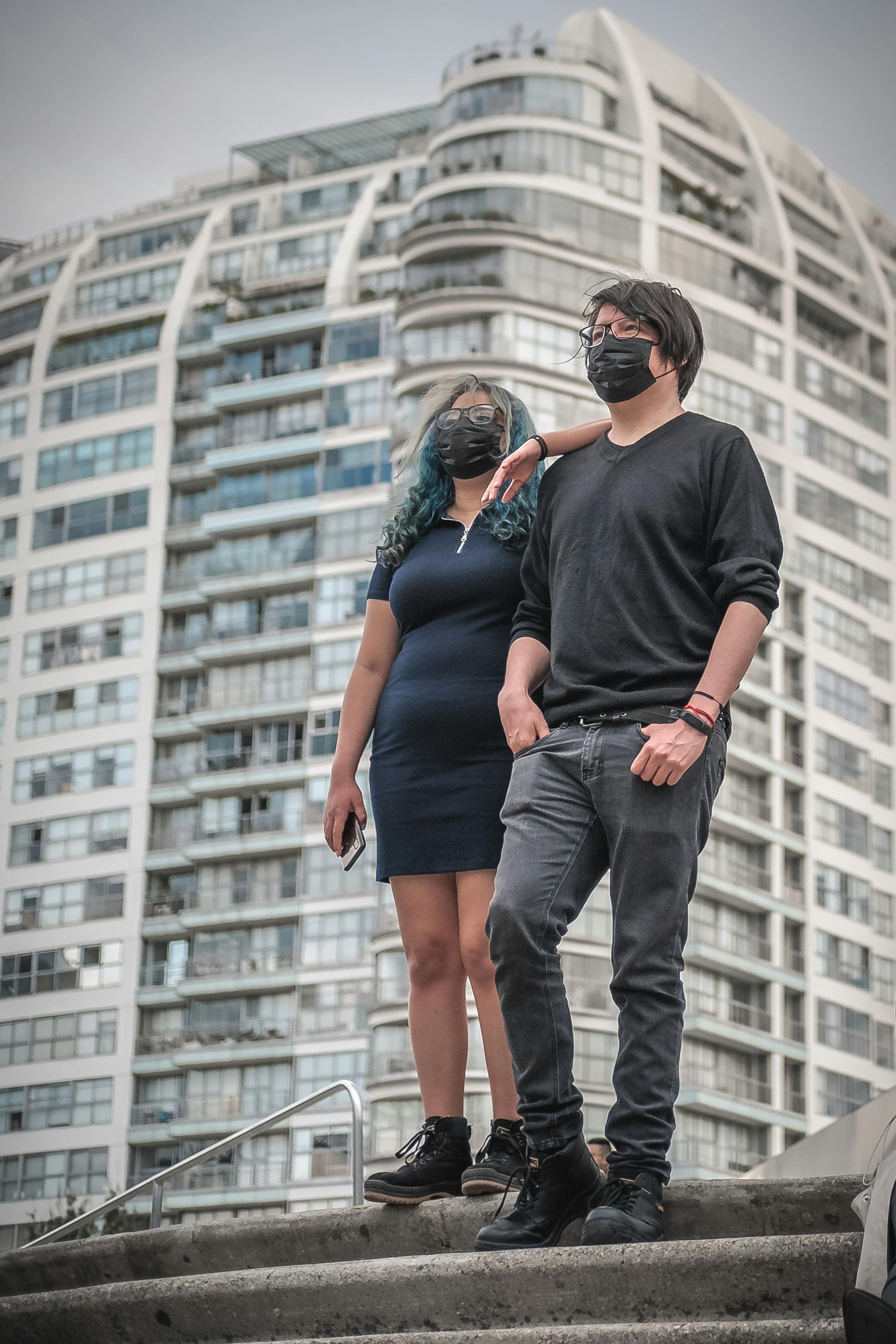 Couple Wearing Protective Face Masks Standing Side by Side Against a ...