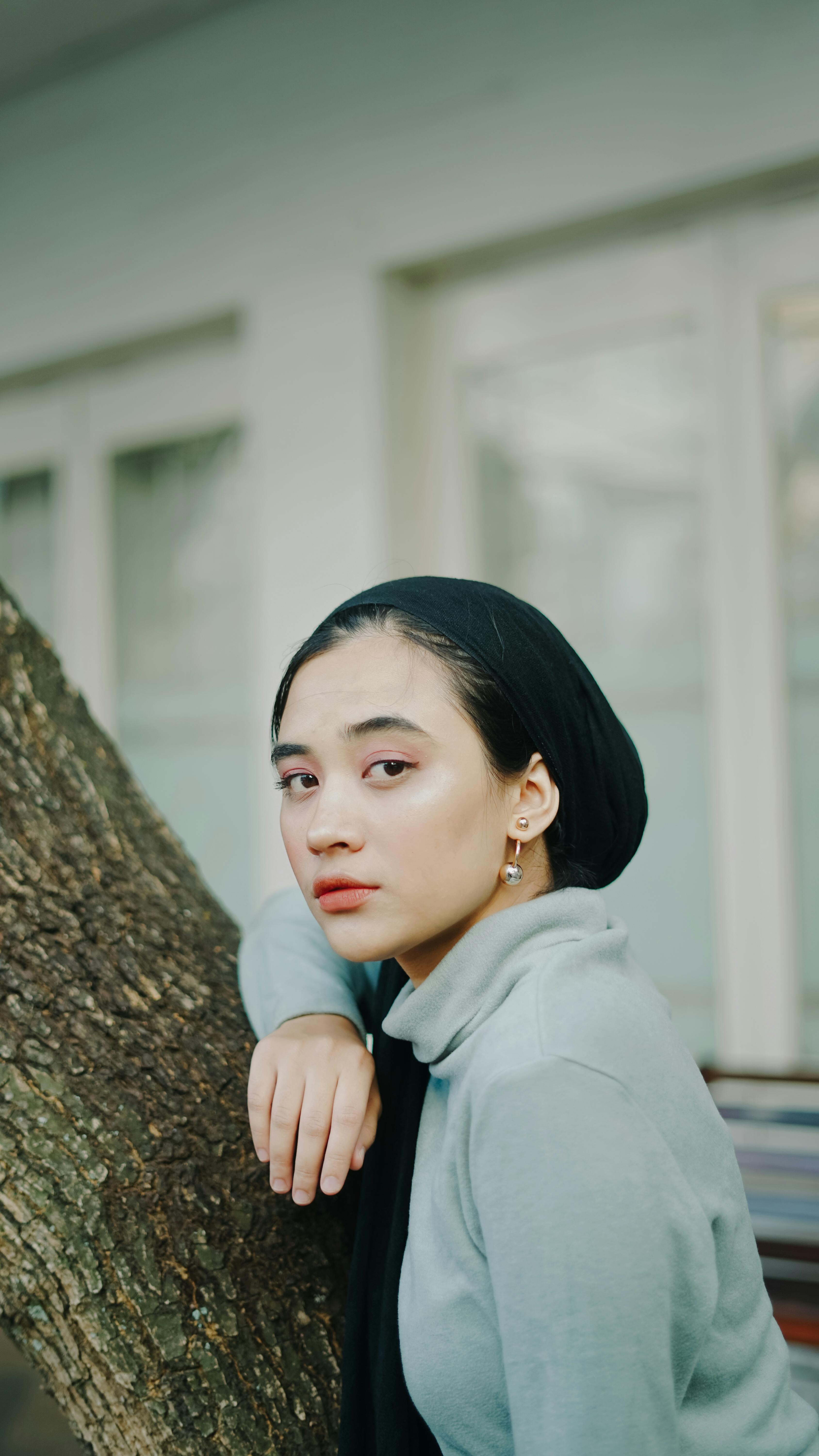Portrait of a Woman Leaning against a Tree · Free Stock Photo