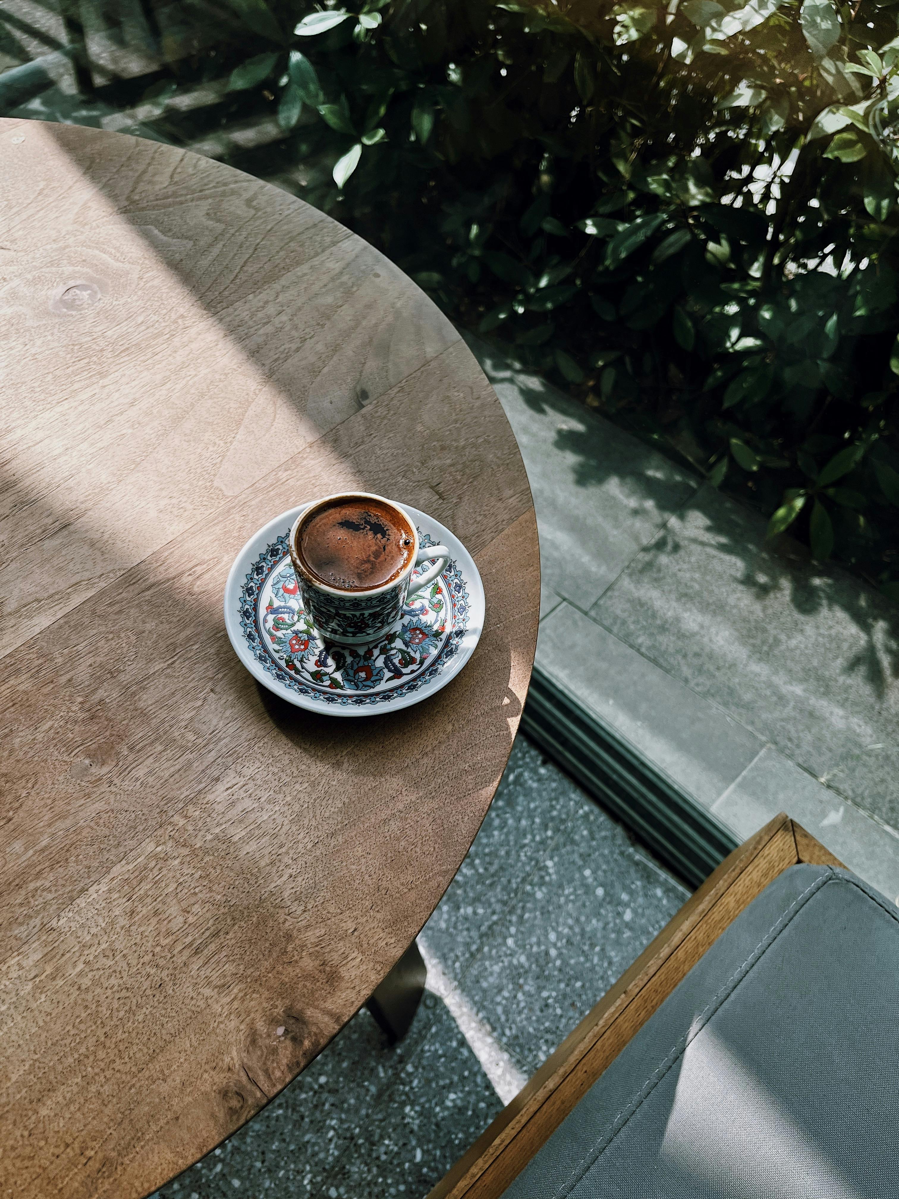 Cup of Coffee on Top of a Round Wooden Table · Free Stock Photo