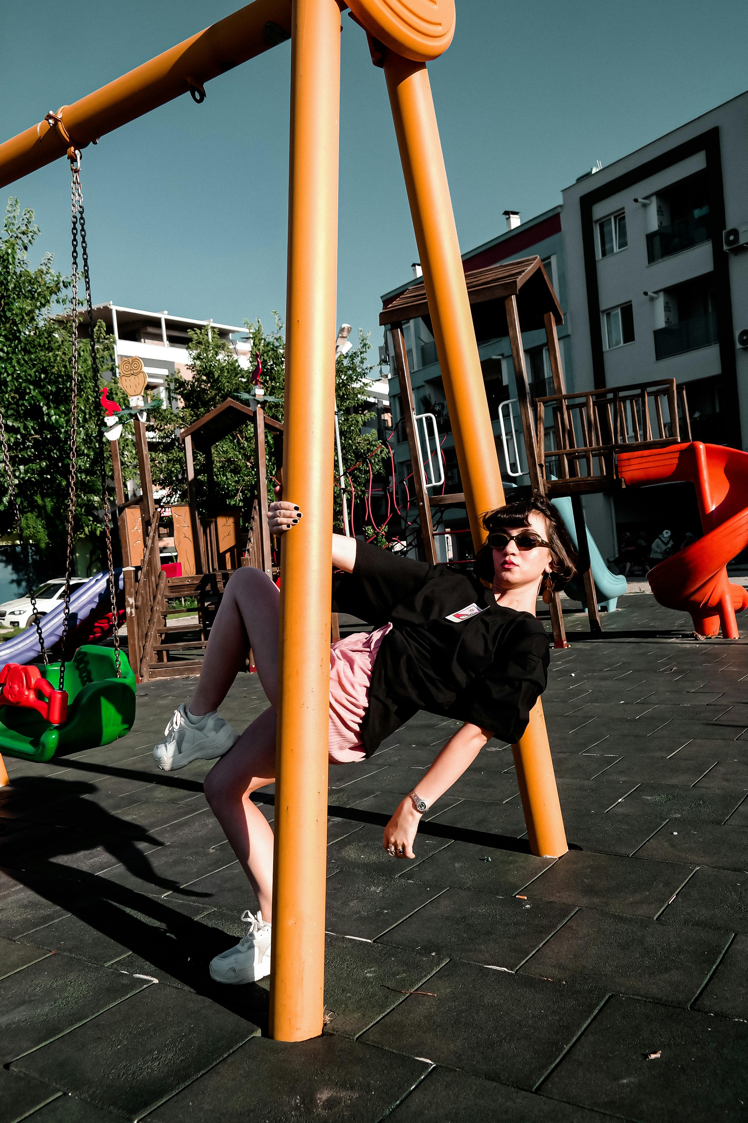 Stylish Woman Posing on a Swing Post · Free Stock Photo
