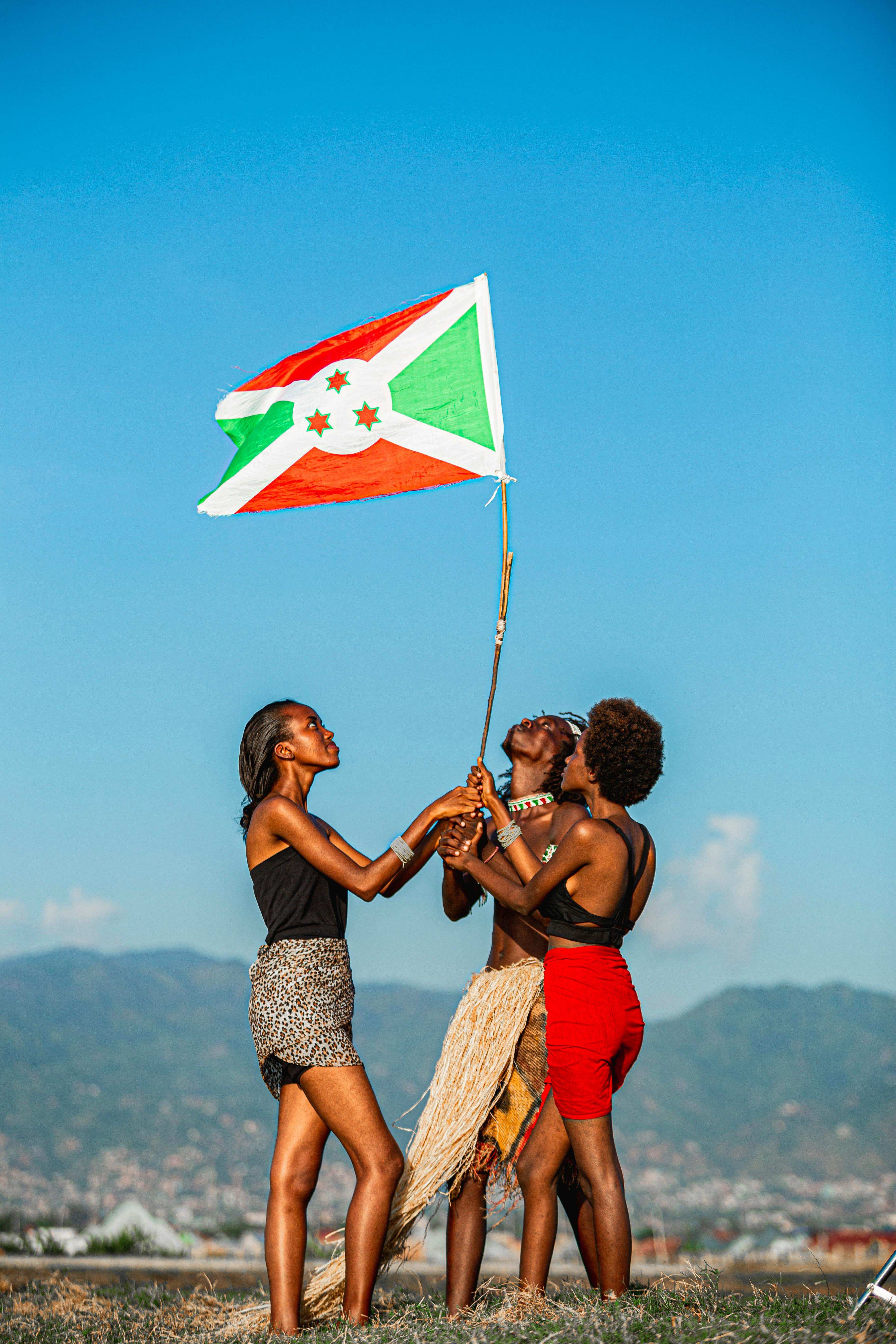 Group of People Raising a Flag Together · Free Stock Photo