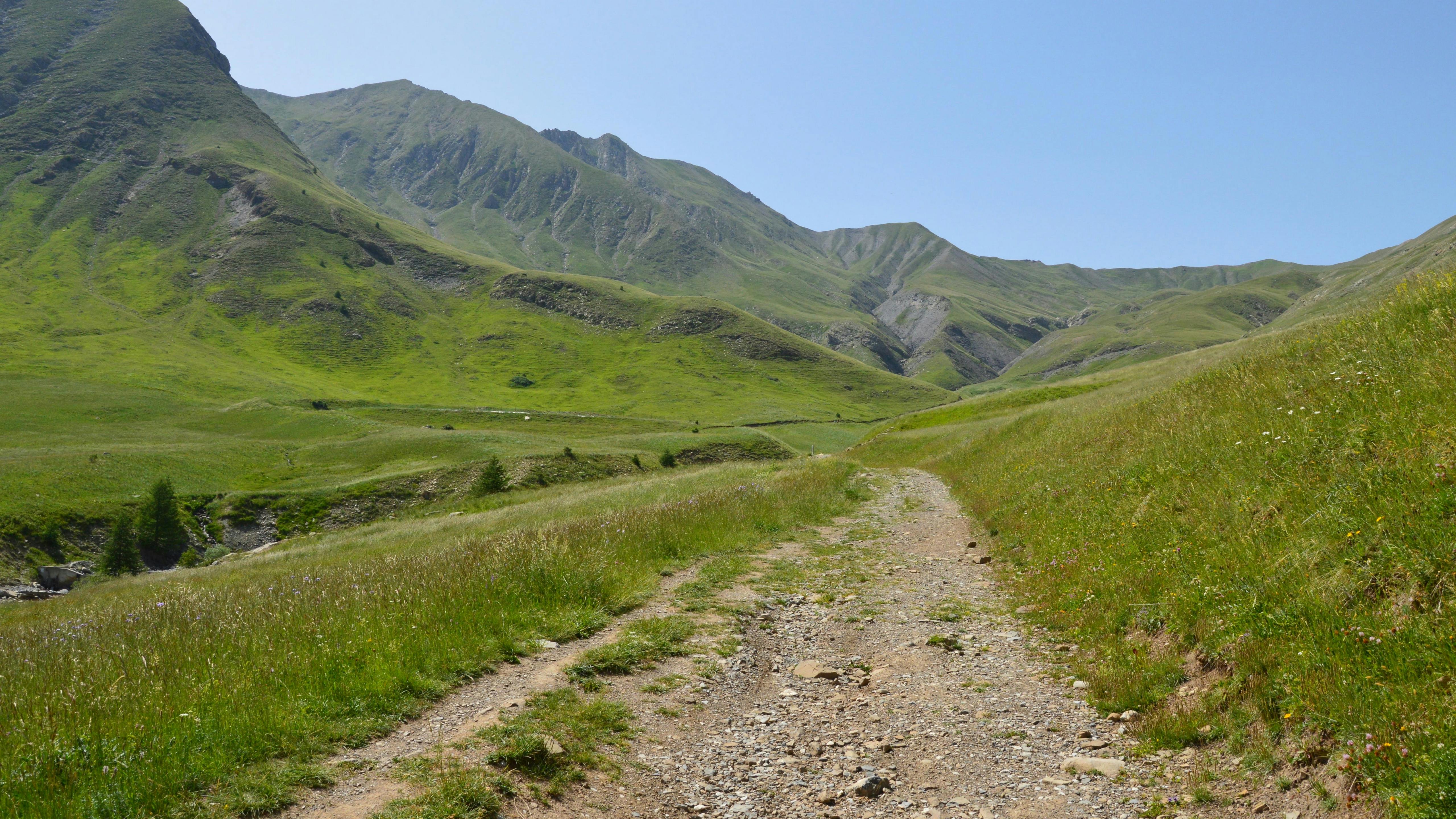 Unpaved Pathway on Green Grass Field near the Mountains · Free Stock Photo