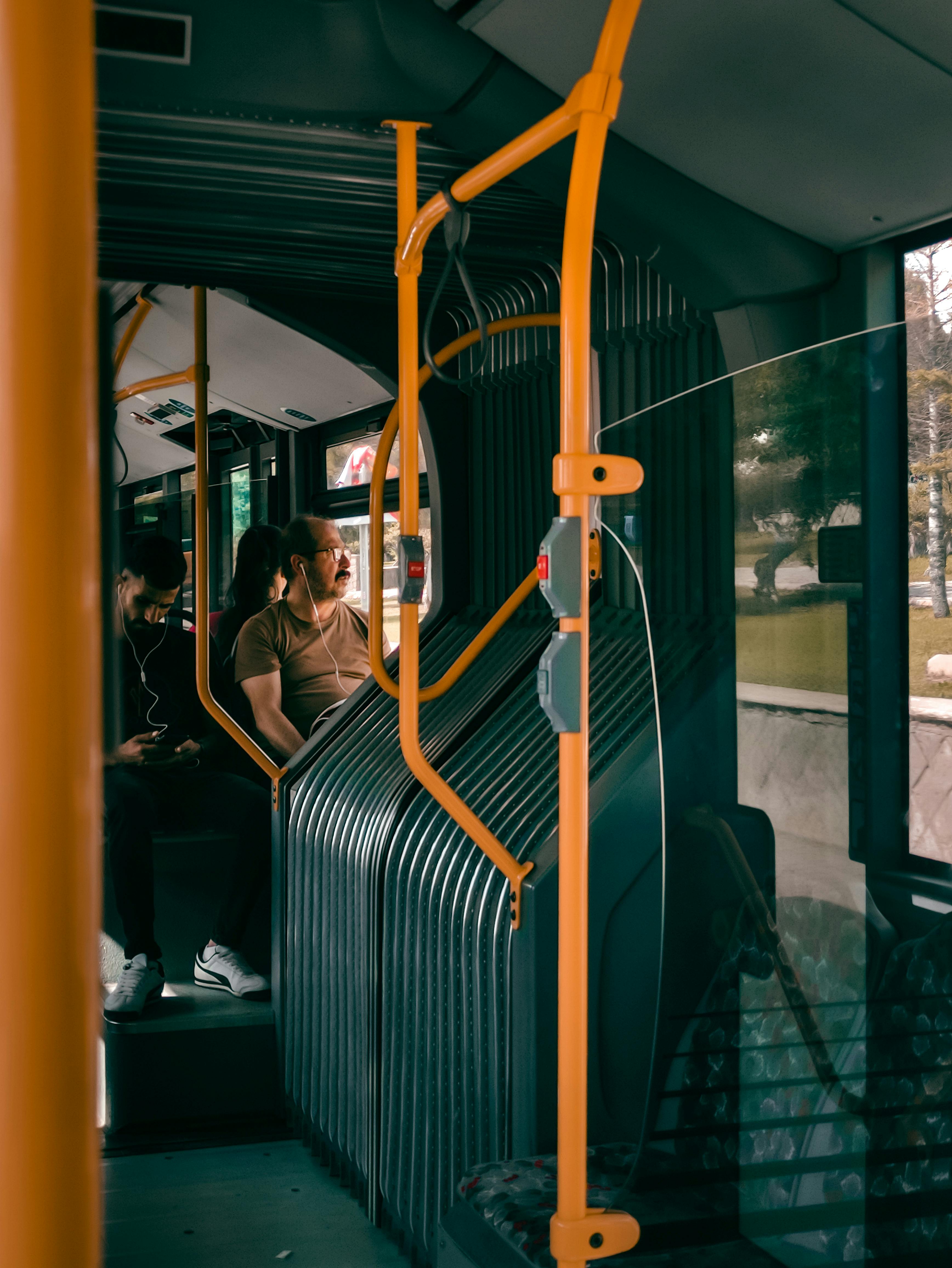 A Man in Brown Shirt Sitting on Train Seat · Free Stock Photo