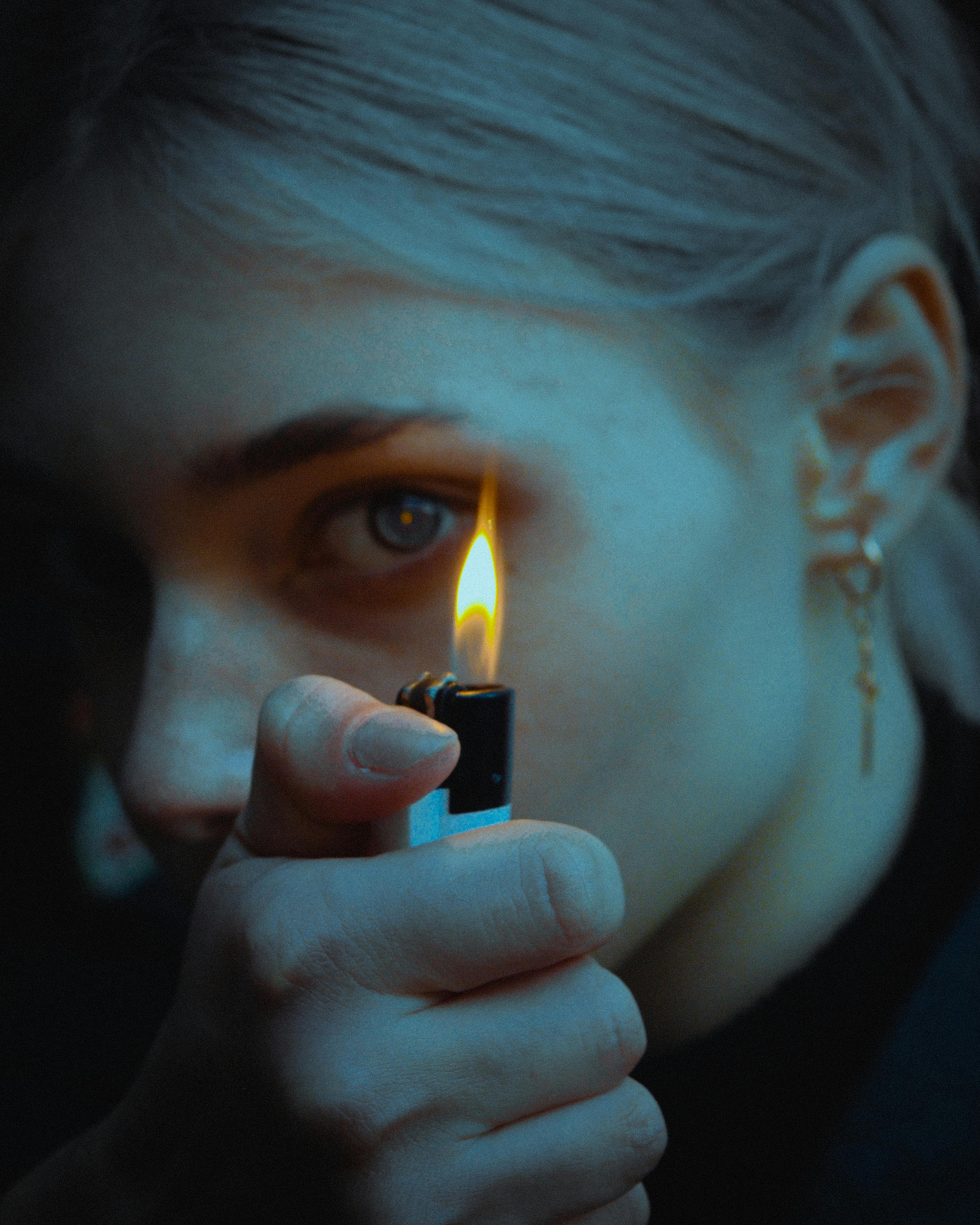Woman Holding a Lit Lighter in Front of Her Face · Free Stock Photo