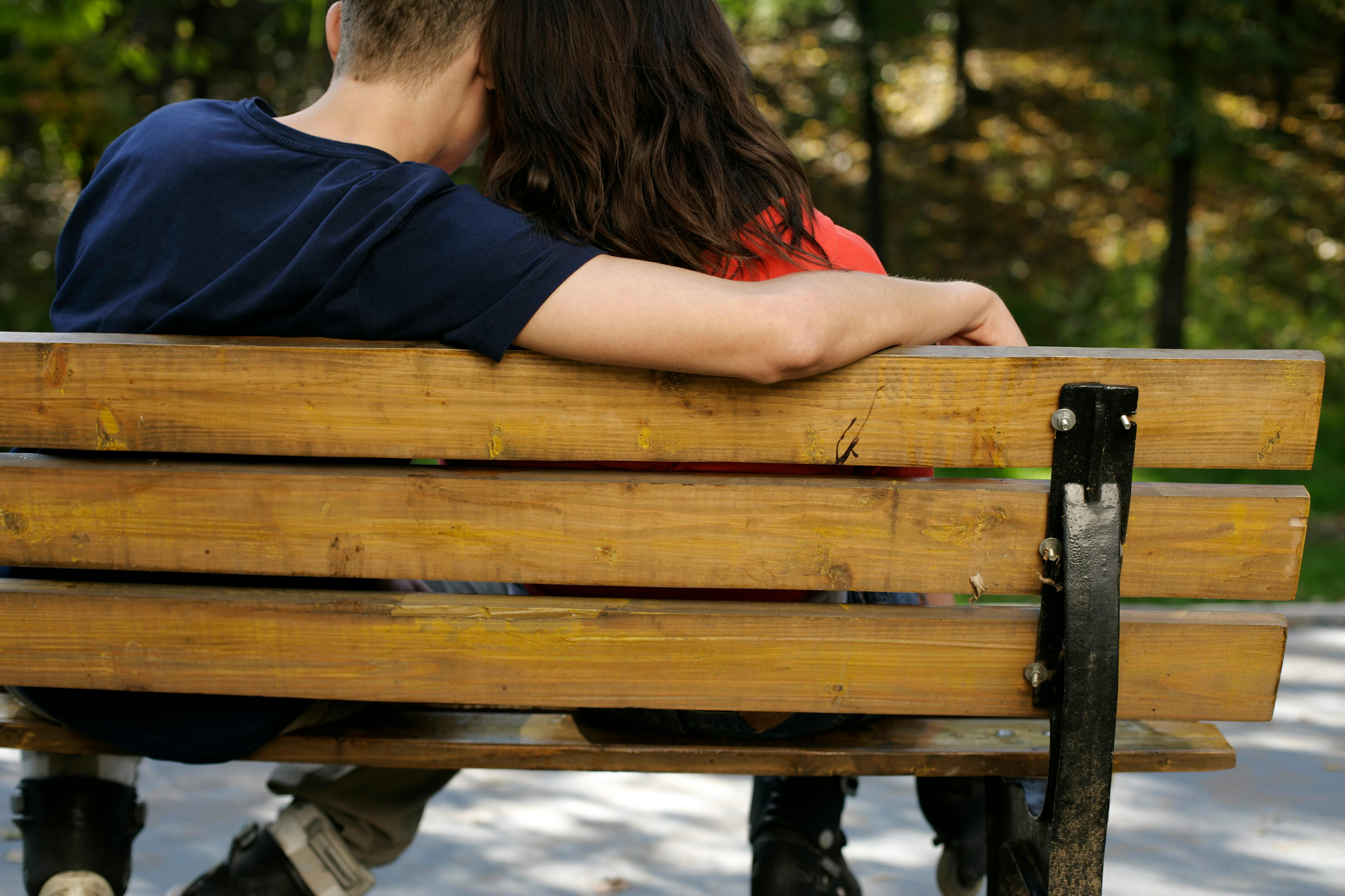 Back View of a Hugging Couple Sitting on the Bench · Free Stock Photo