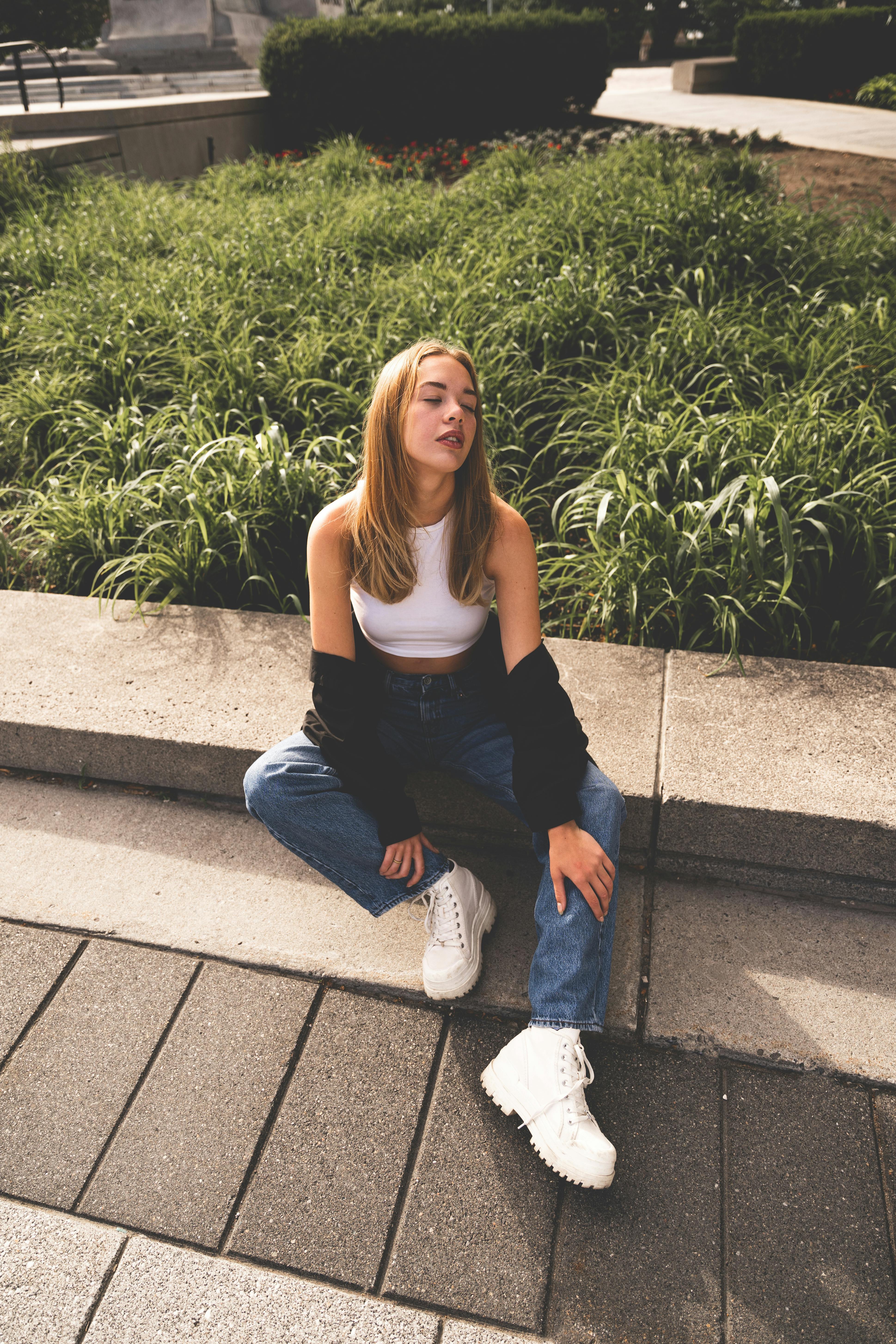 Woman in White Crop Top Sitting on Concrete Bench · Free Stock Photo