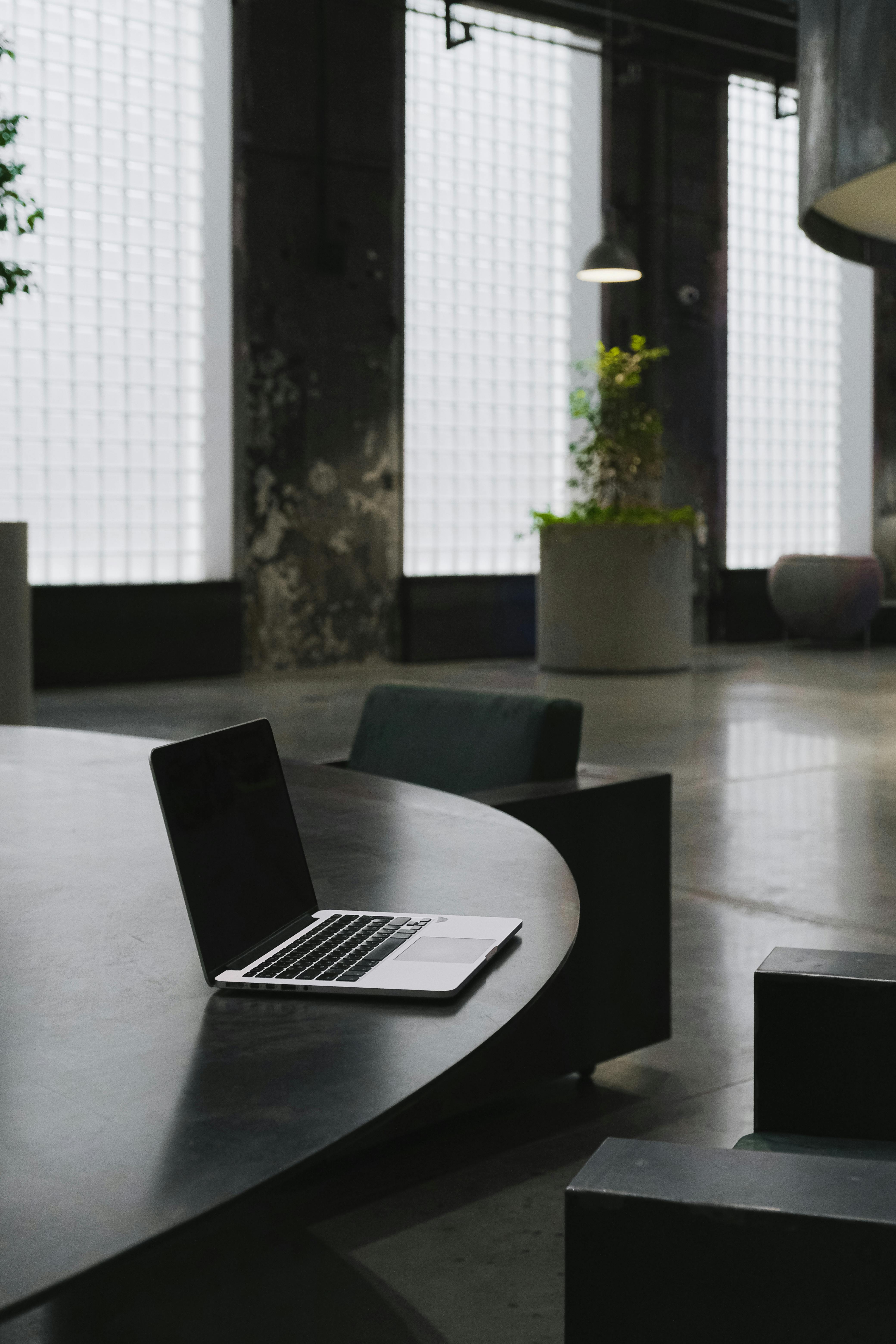 Laptop left on Black Table in Empty Hallway · Free Stock Photo