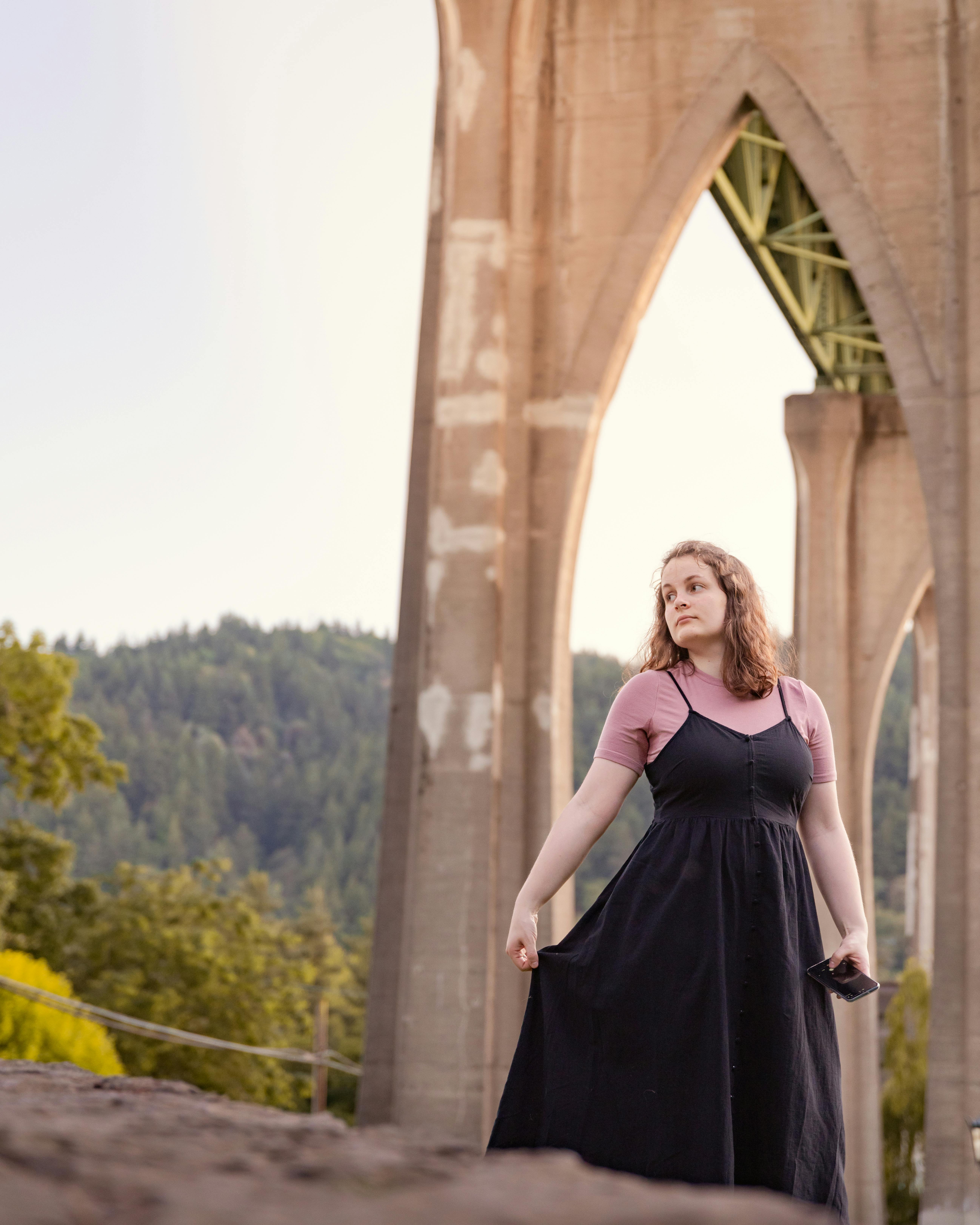 Posed Photo of a Girl in a Black Dress Standing under a Bridge and ...