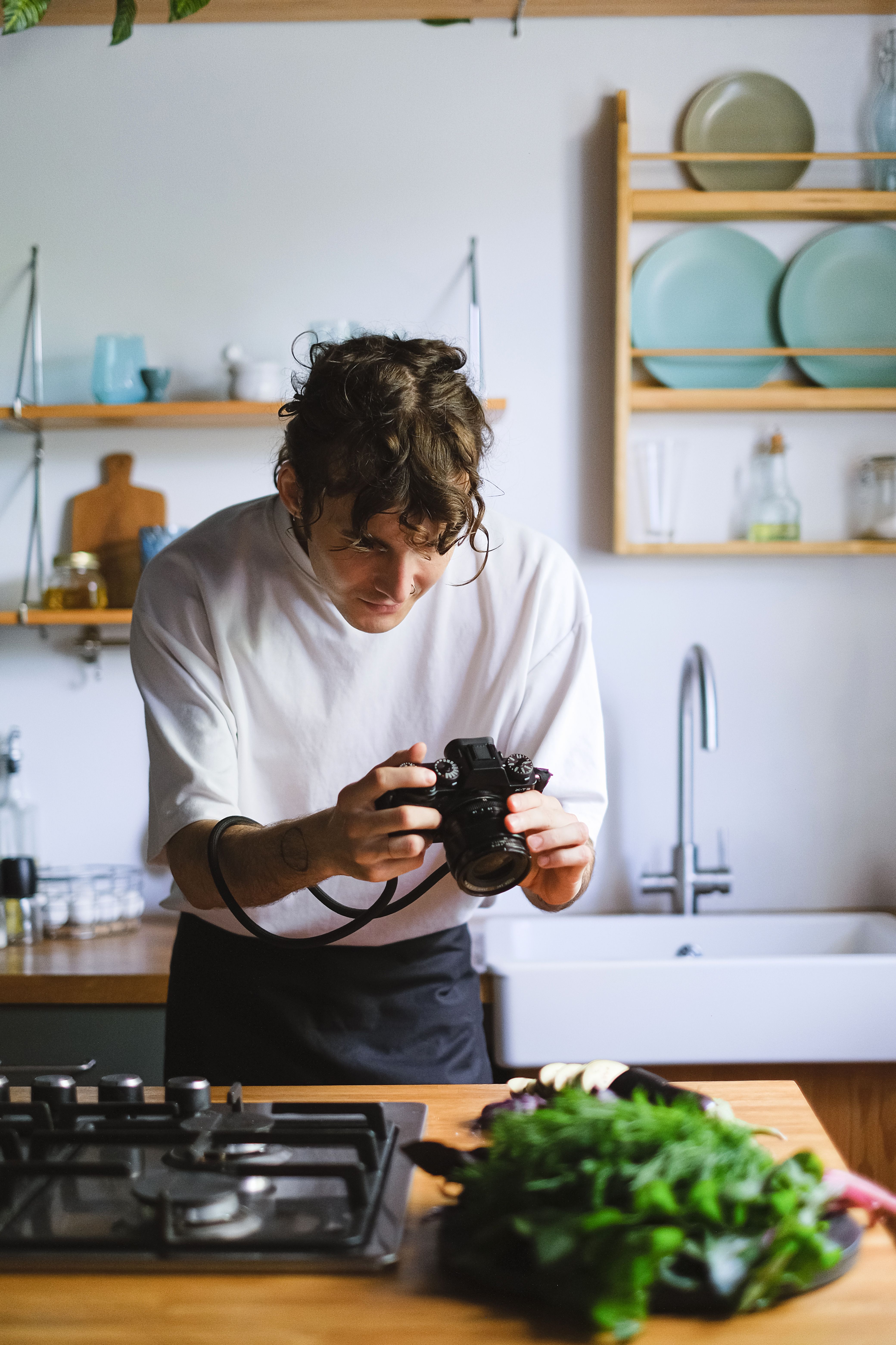 Vlogger Recording Himself Cooking in a Kitchen · Free Stock Photo