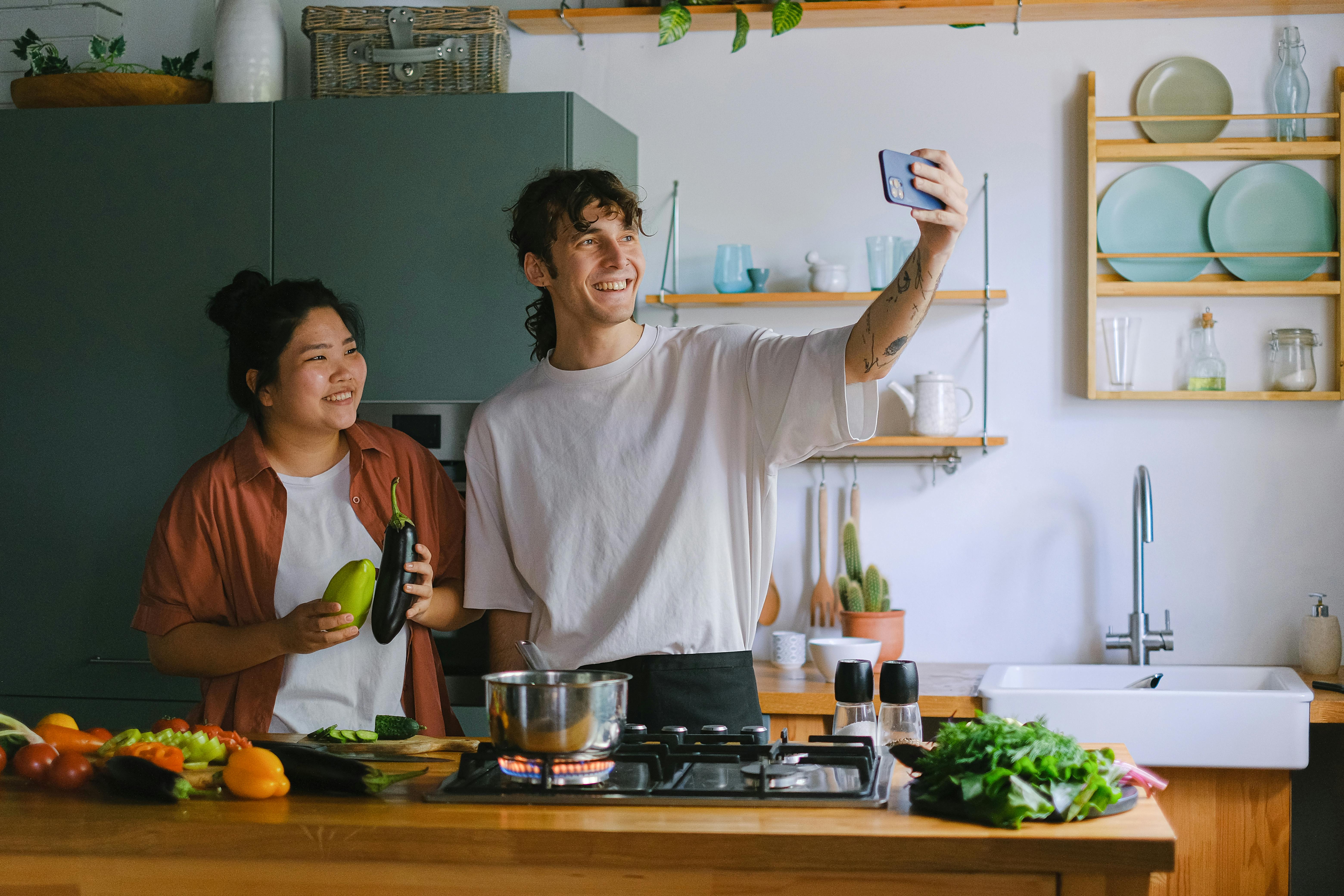 Woman Using a Phone while Cooking in a Kitchen · Free Stock Photo