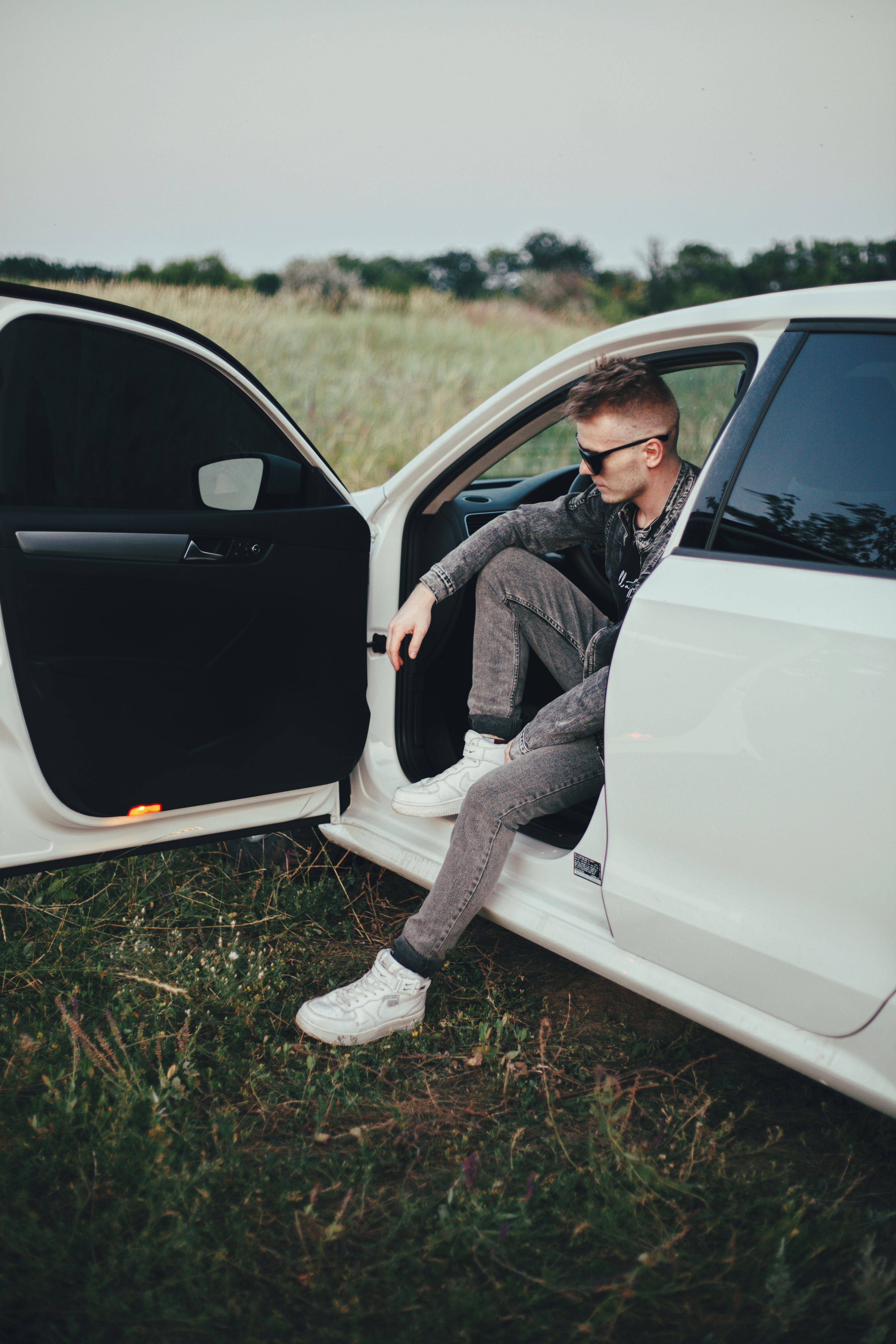 Man Sitting Beside His White Car · Free Stock Photo