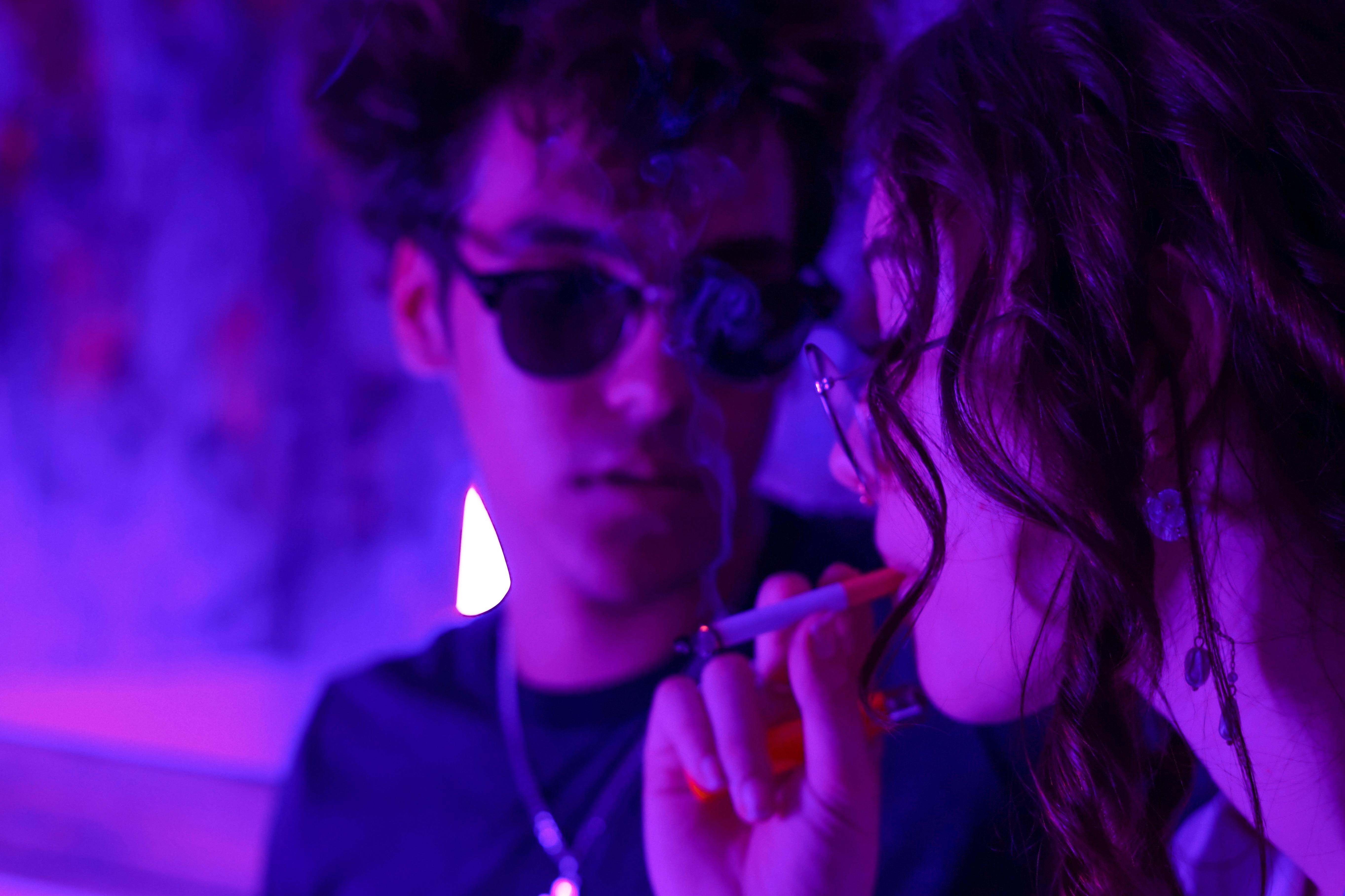 A Man Smoking Cigarette while Eating Chips · Free Stock Photo