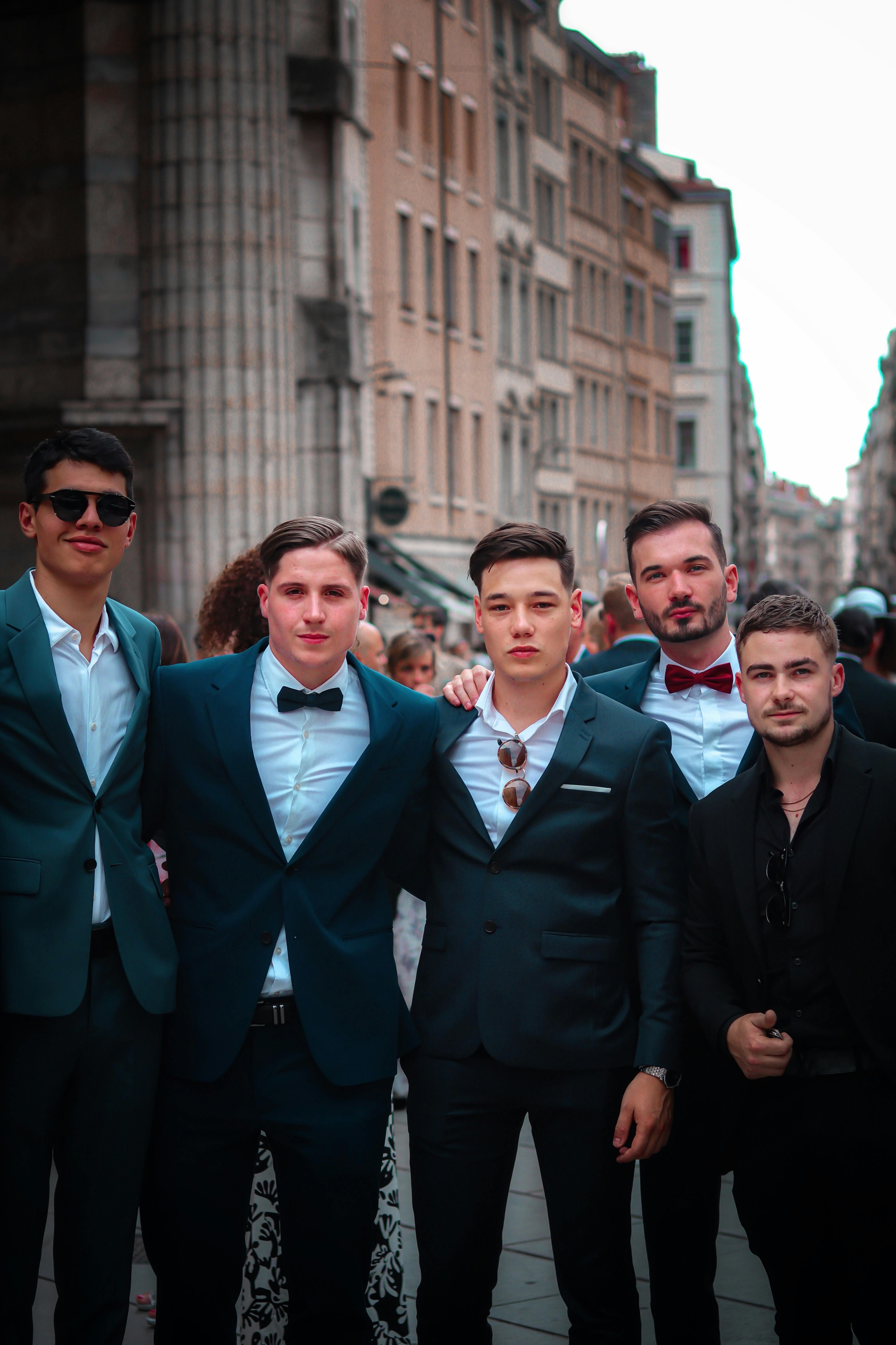 Man in Black Suit leaning on a Wooden Post · Free Stock Photo