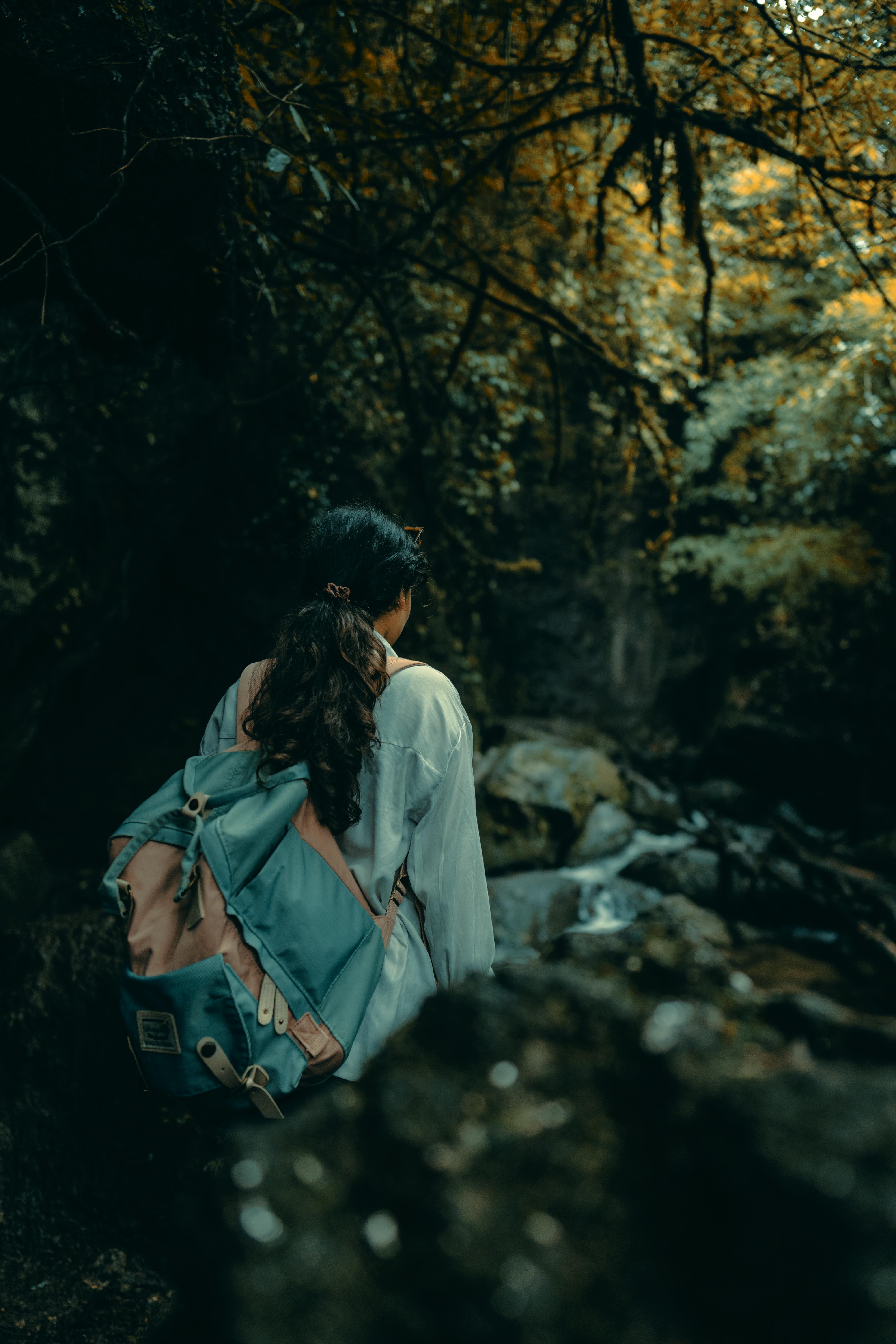 A Woman Carrying a Backpack in the Forest · Free Stock Photo