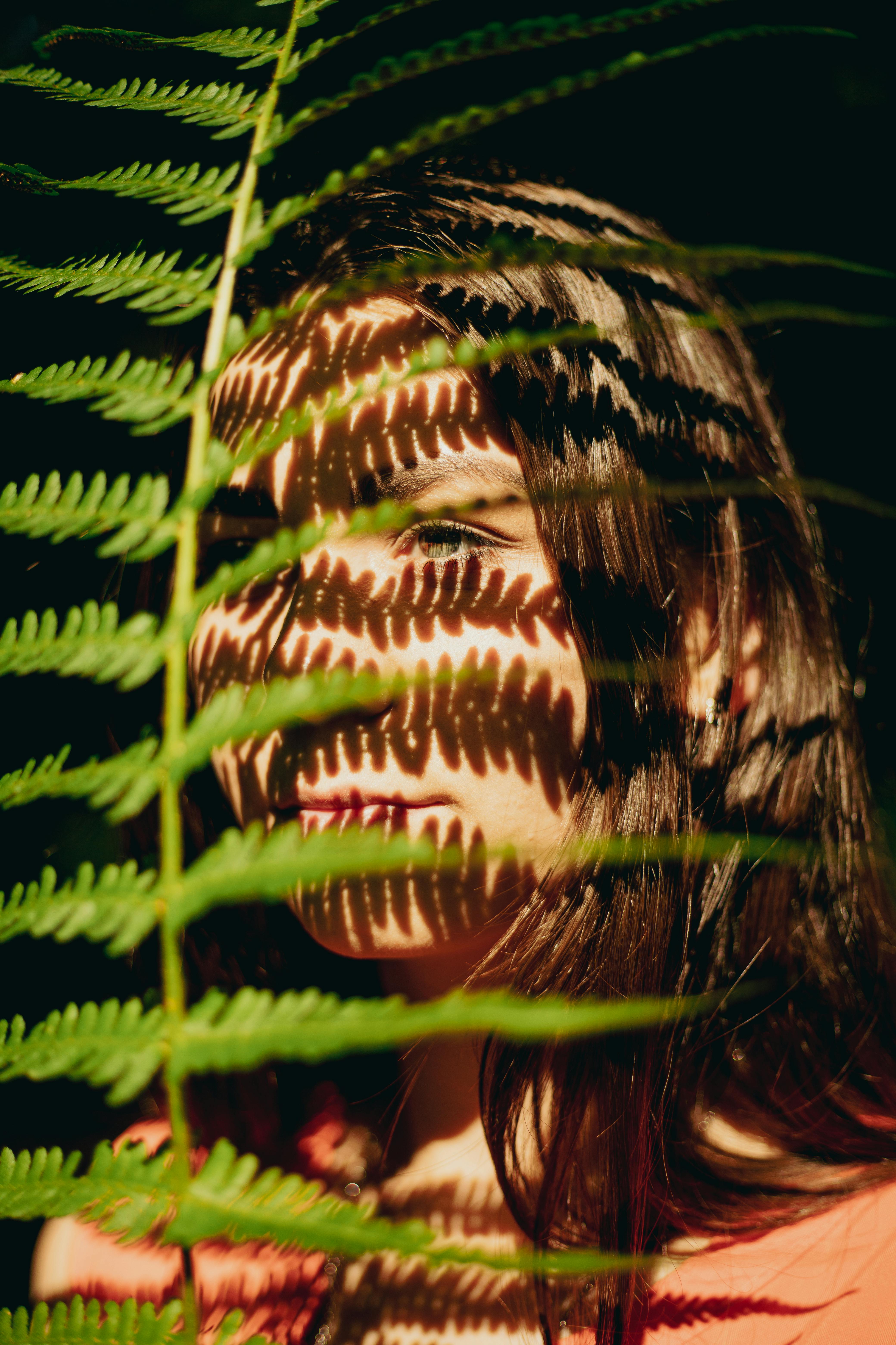 A Woman's Face Behind the Fern Leaf · Free Stock Photo