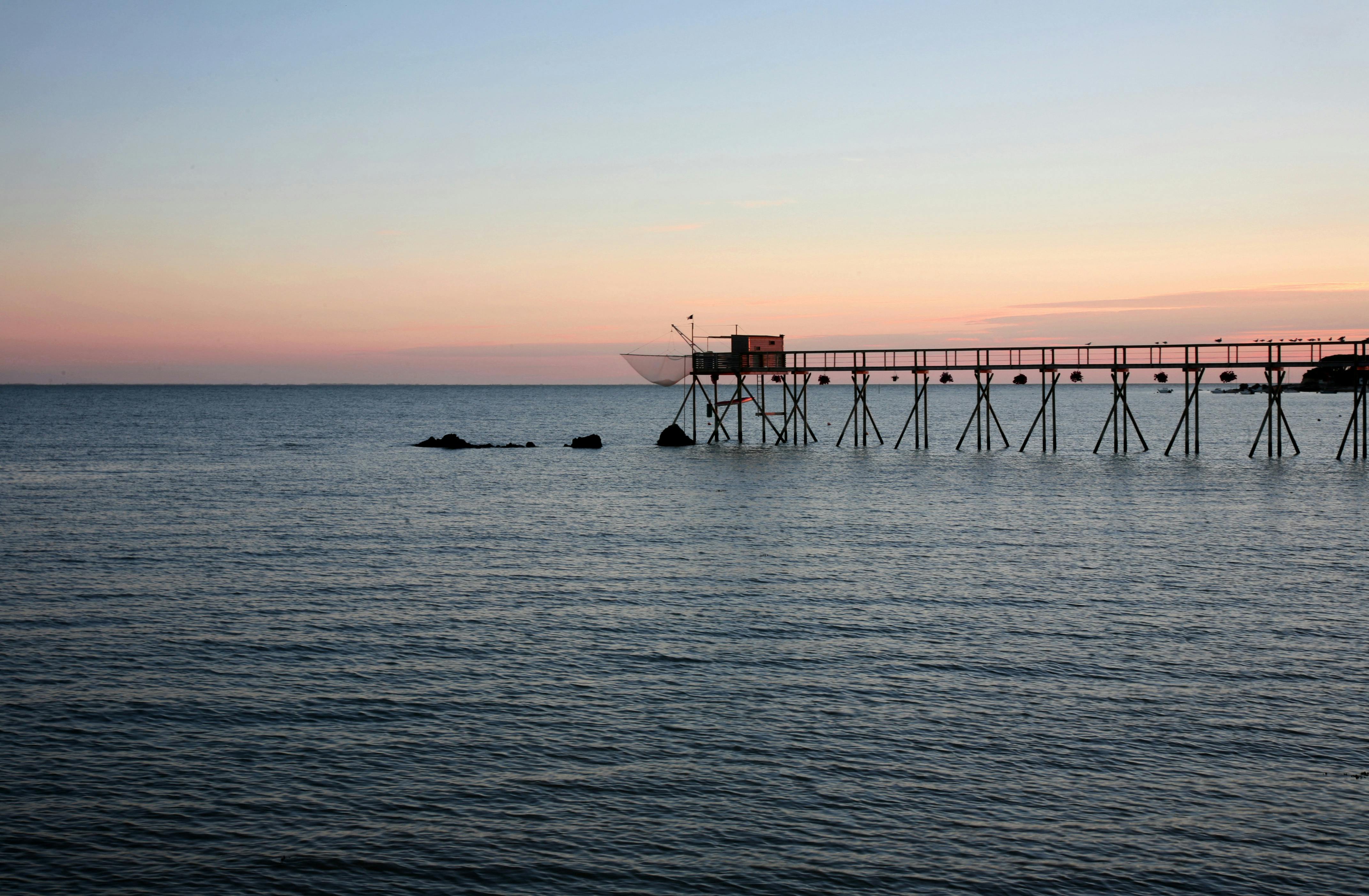 A Jetty on a Body of Water at Dusk · Free Stock Photo