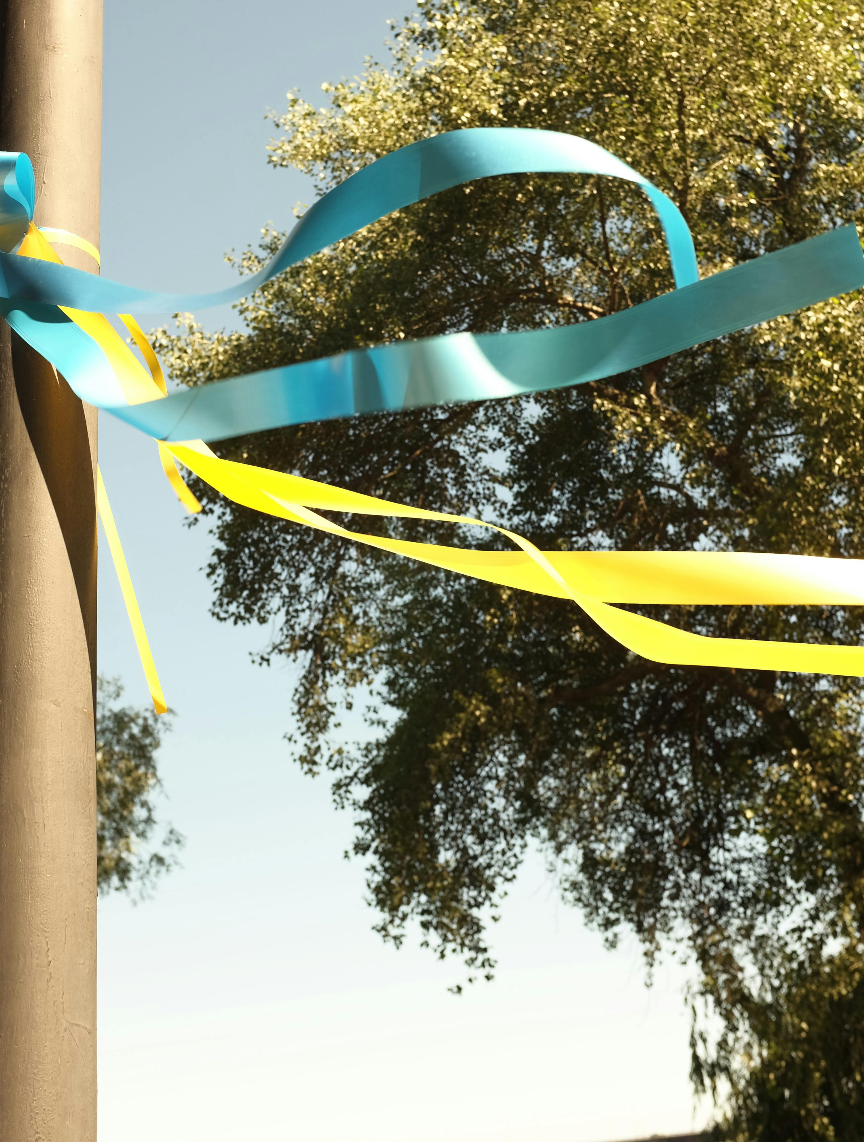 Blue and Yellow Ribbons Tied to a Pole · Free Stock Photo