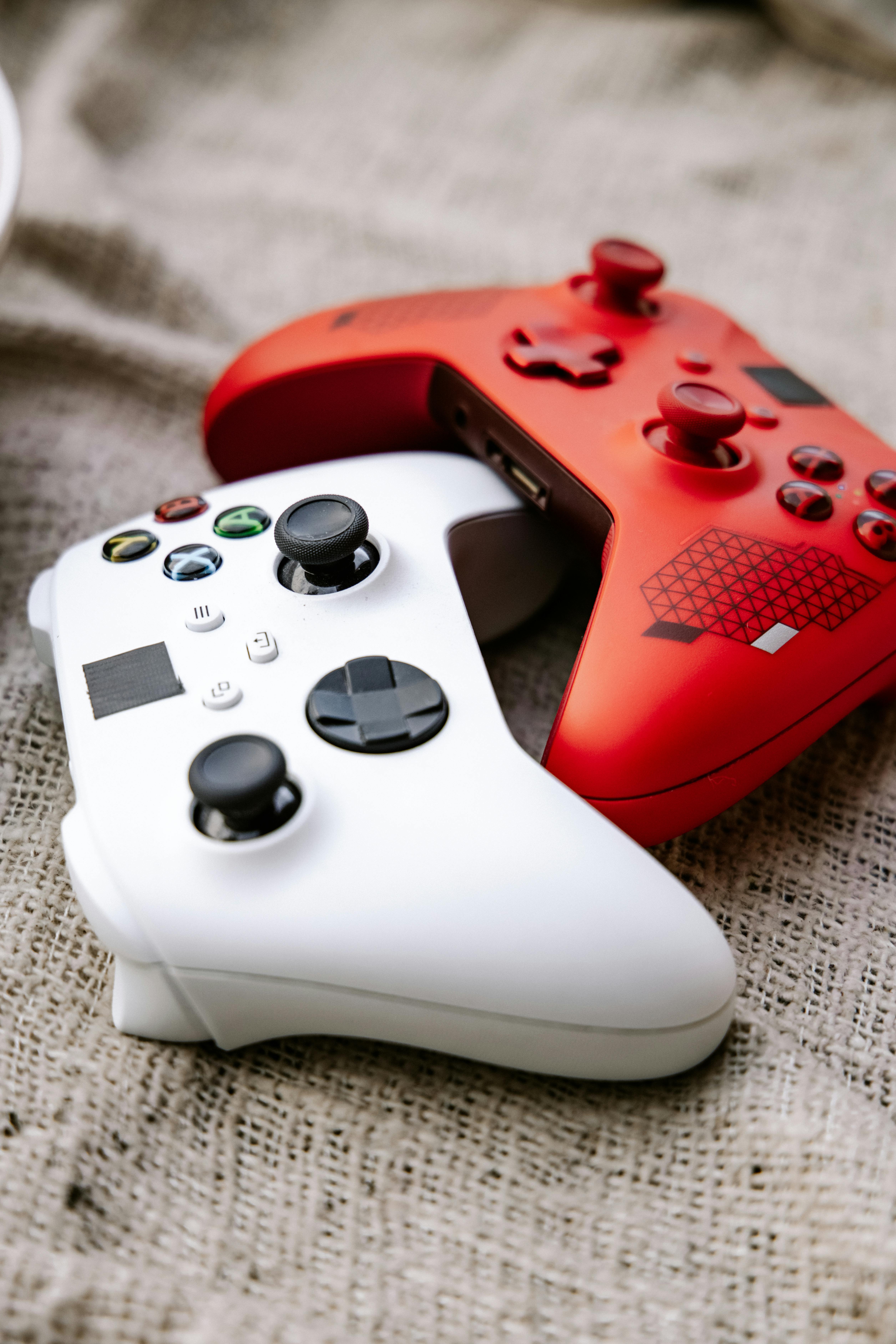 A Photo of Red and White Xbox Wireless Controllers · Free Stock Photo